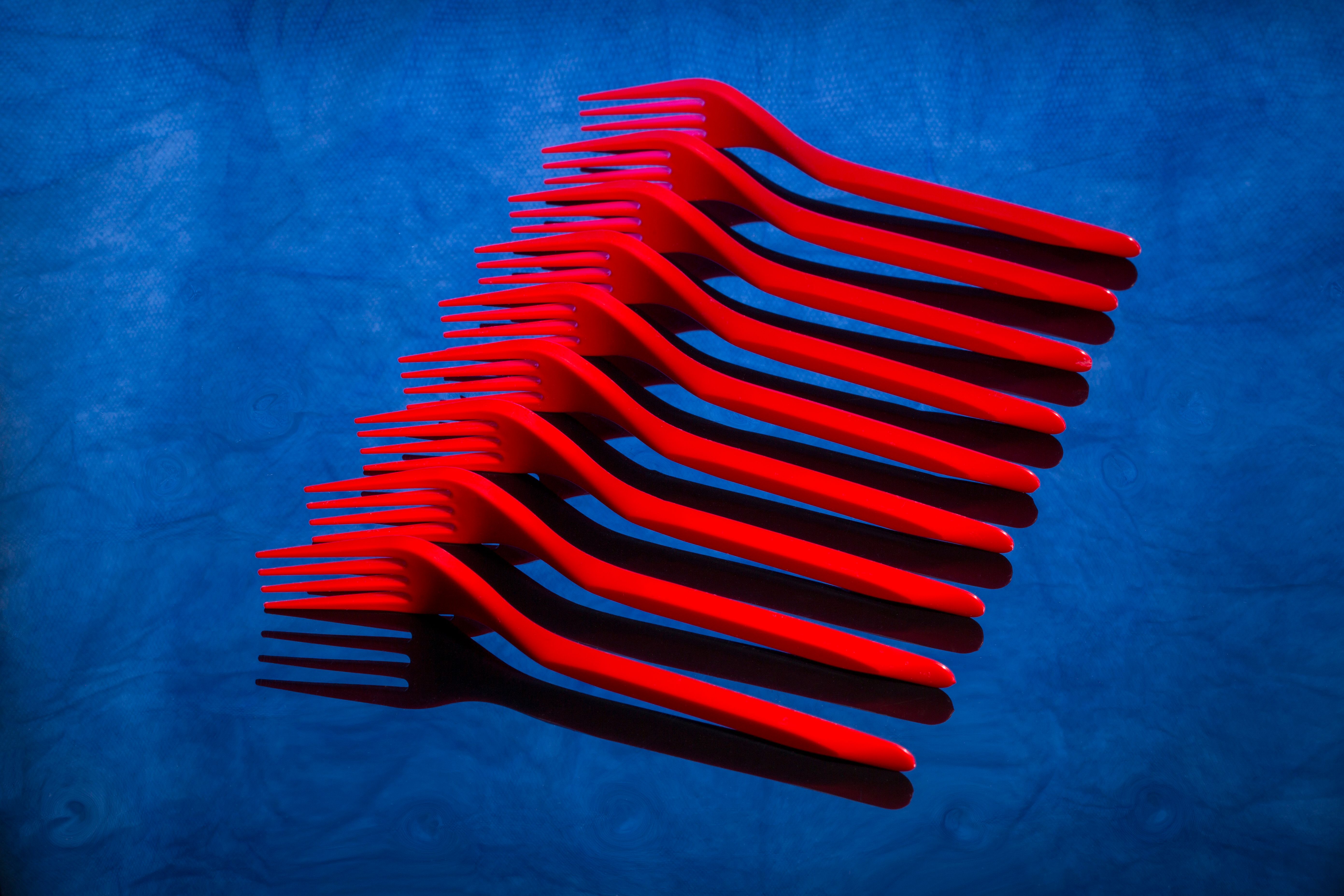 Vibrant Red Forks on Deep Blue Background · Free Stock Photo