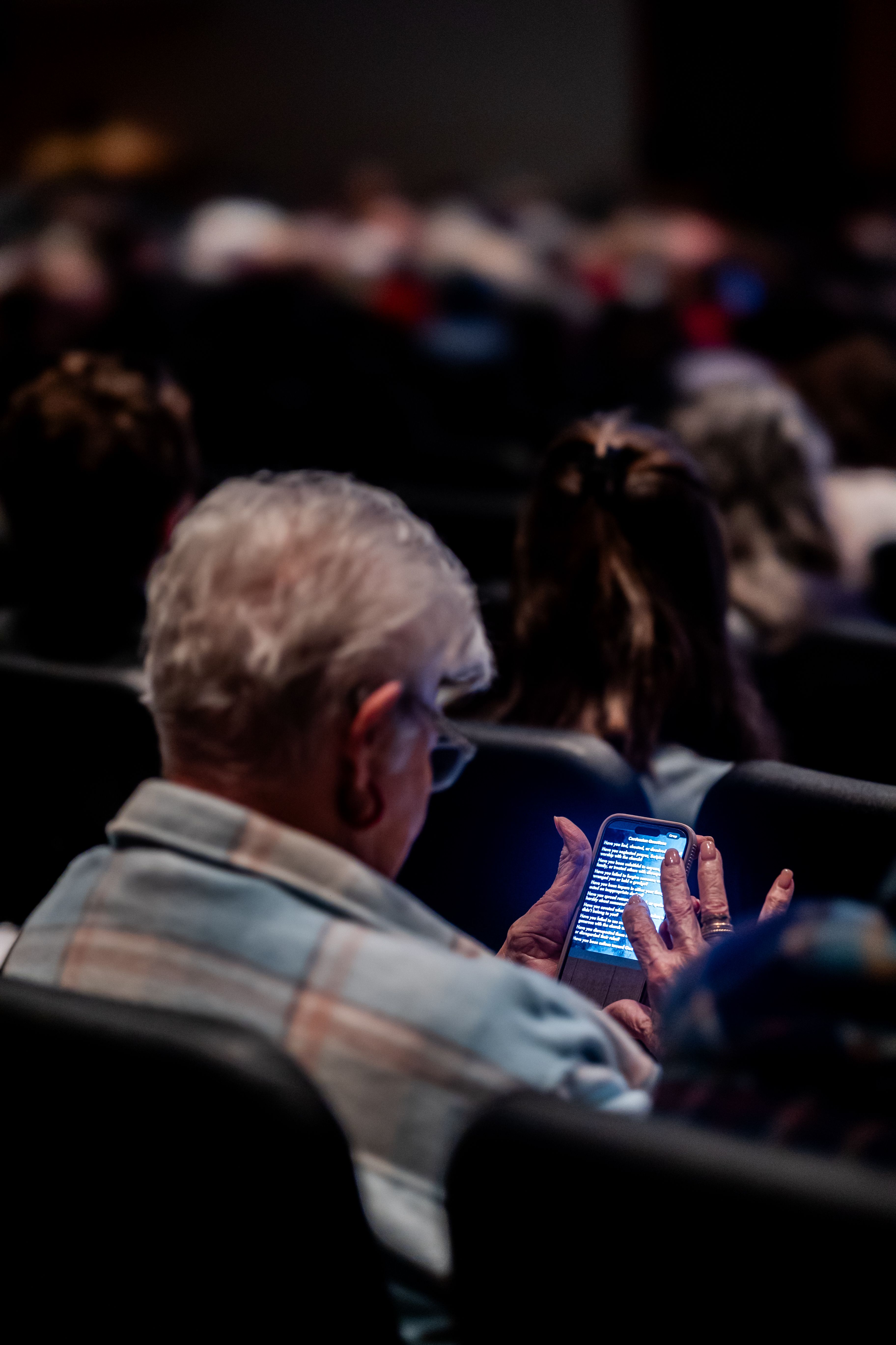 Senior Using Smartphone in Theater Audience · Free Stock Photo