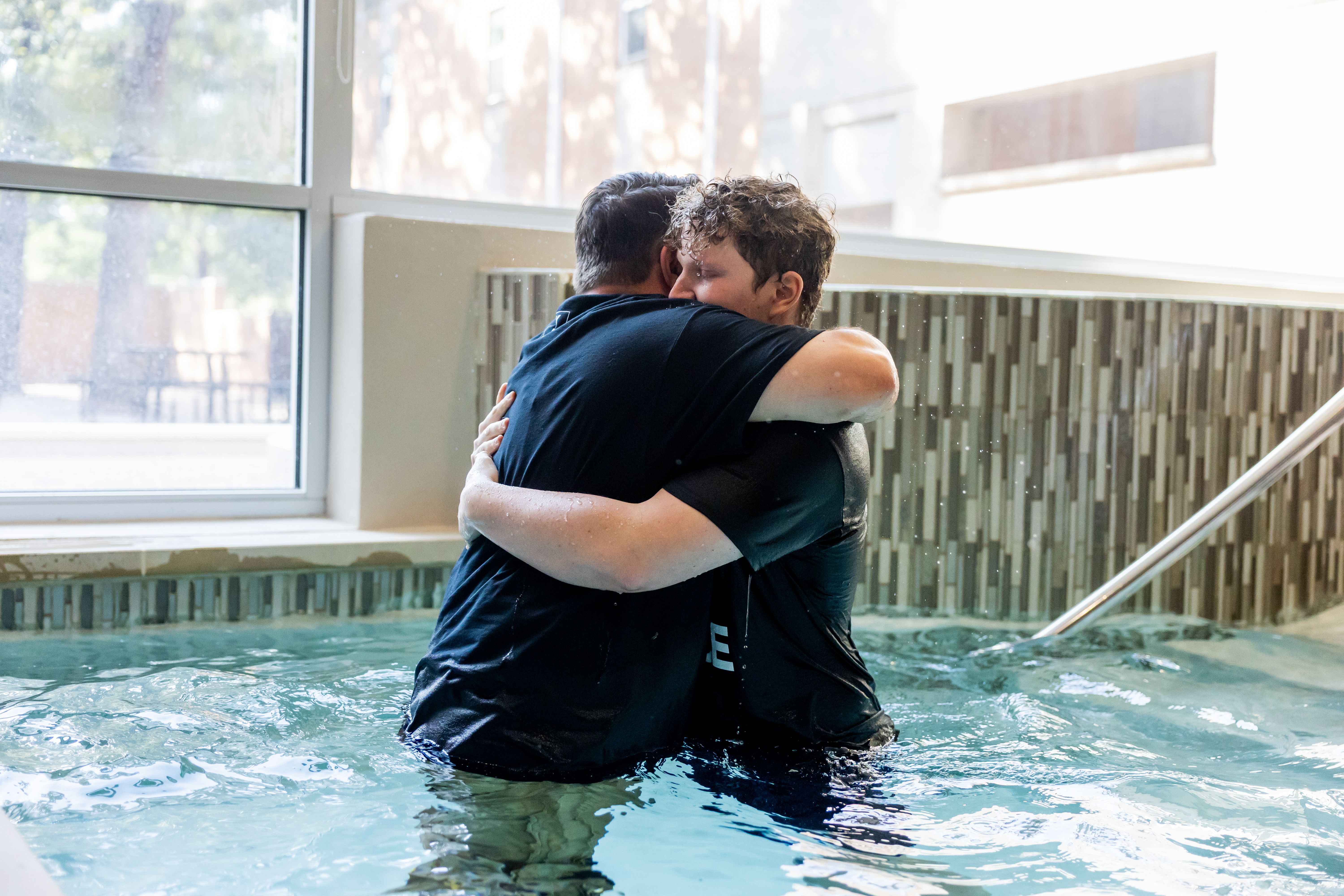 Emotional Baptism Hug in Indoor Pool · Free Stock Photo