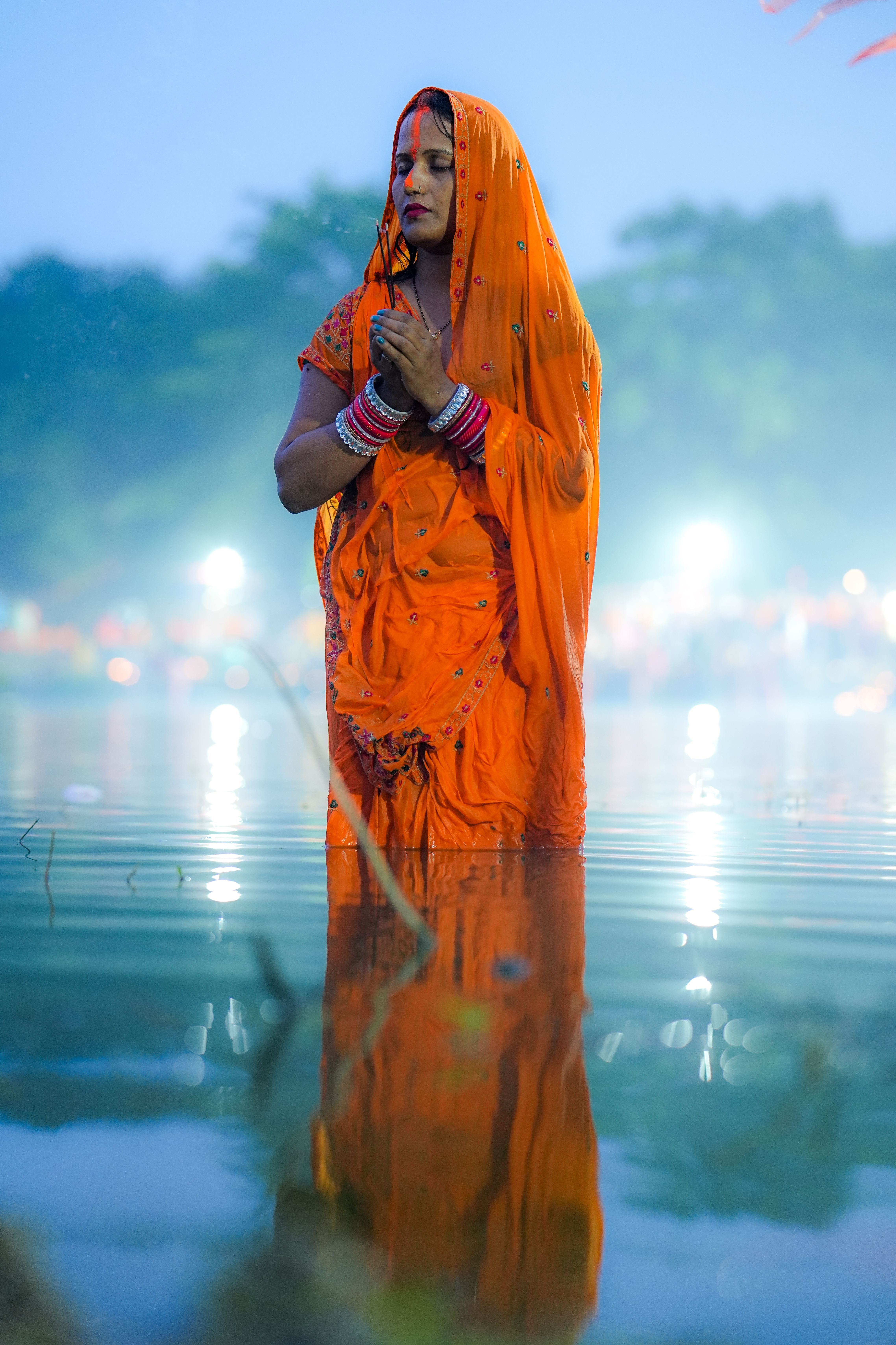 Woman in Orange Saree Praying by the River · Free Stock Photo