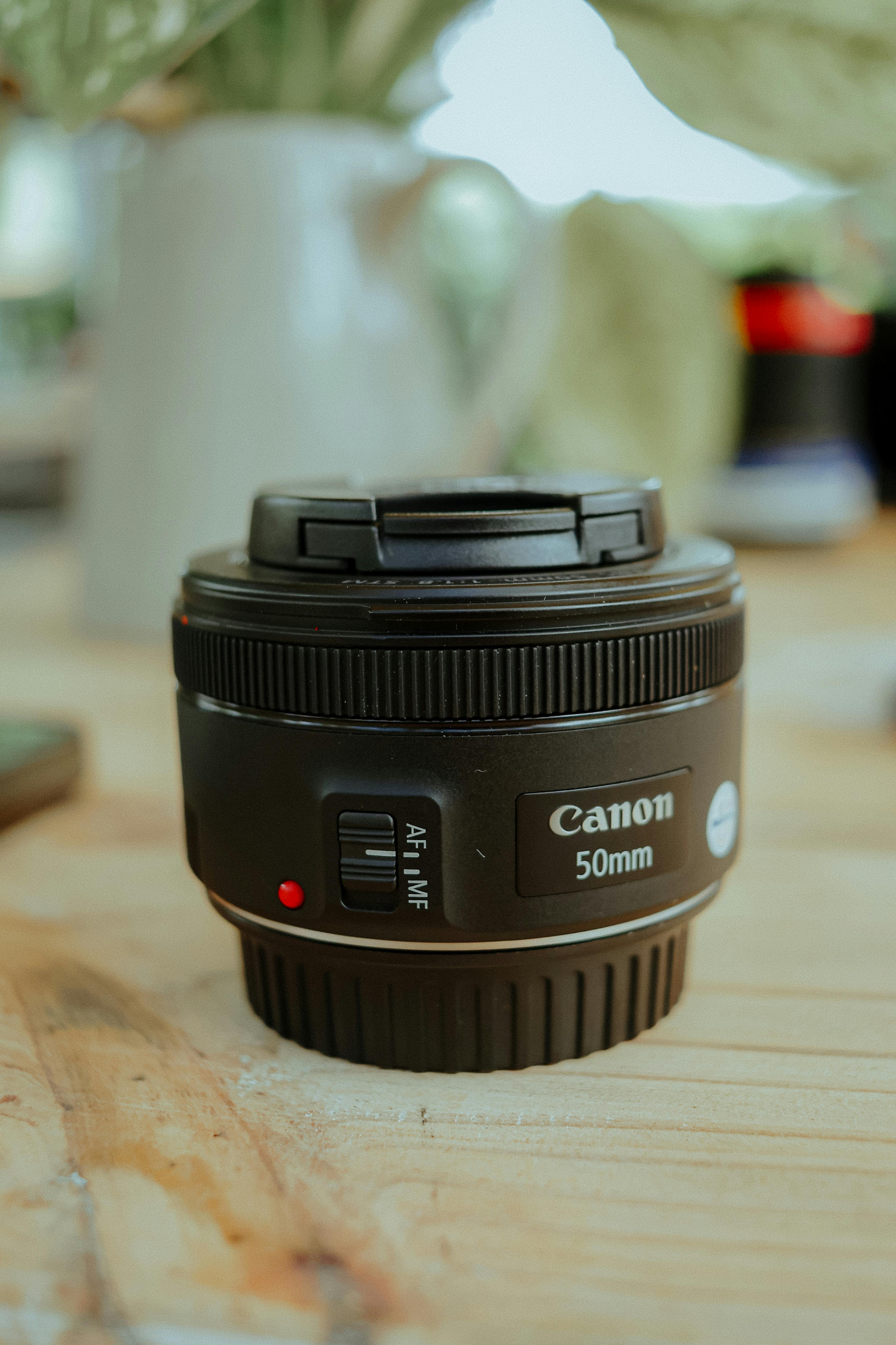 Close-Up of Canon 50mm Camera Lens on Table · Free Stock Photo