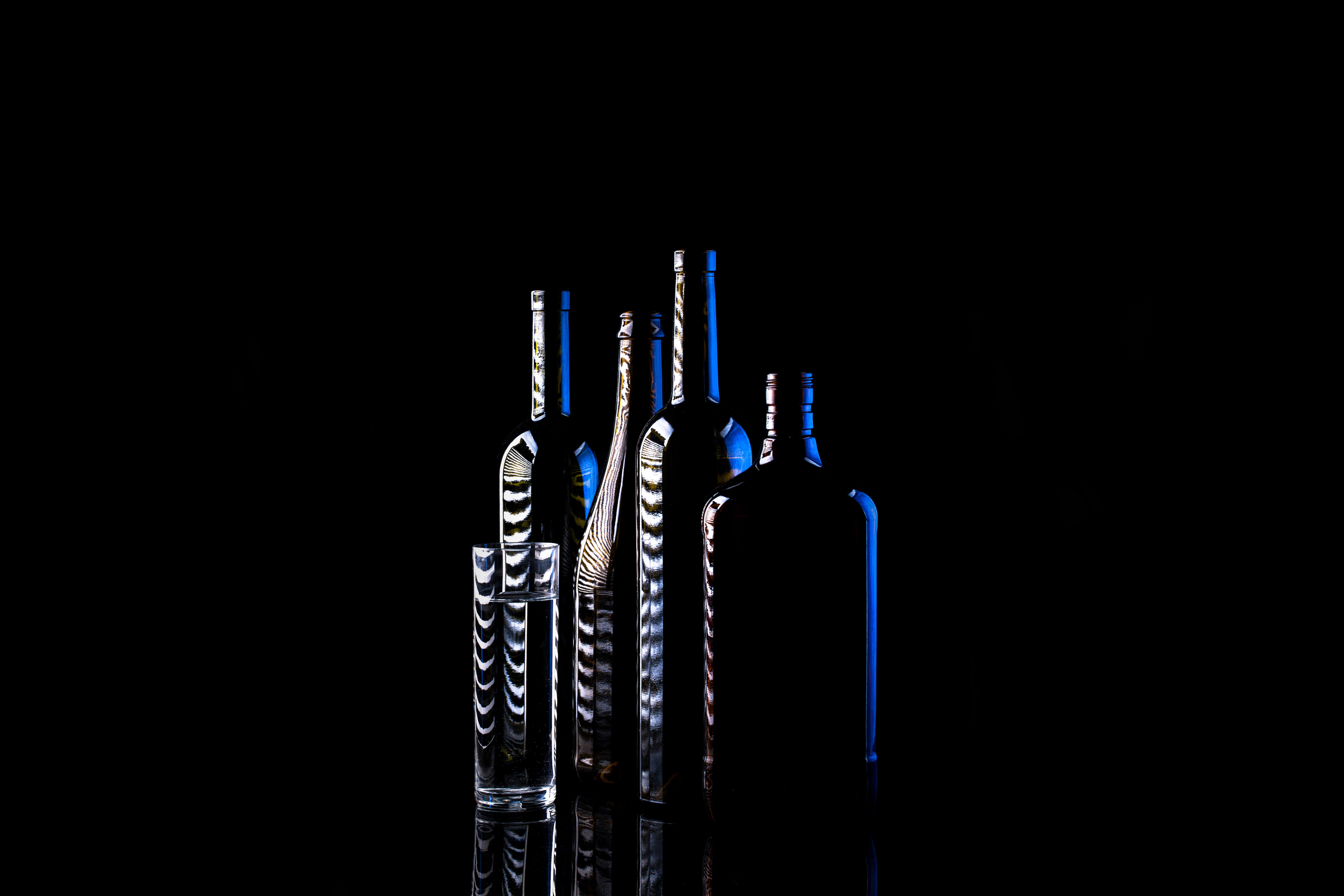 Artistic Display of Glass Bottles with Light Reflections · Free Stock Photo