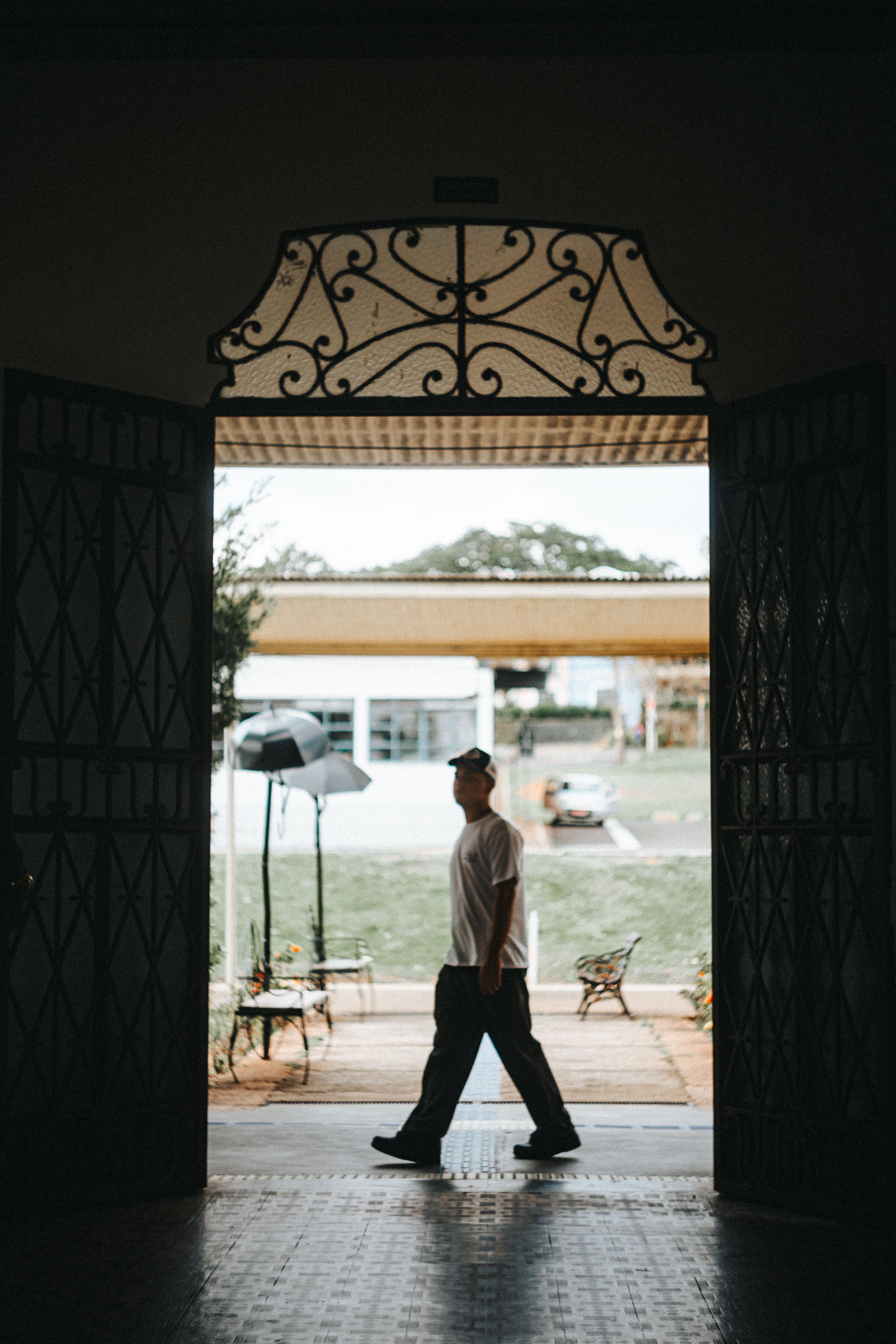 Silhouetted Man Walking Through Ornate Gate · Free Stock Photo
