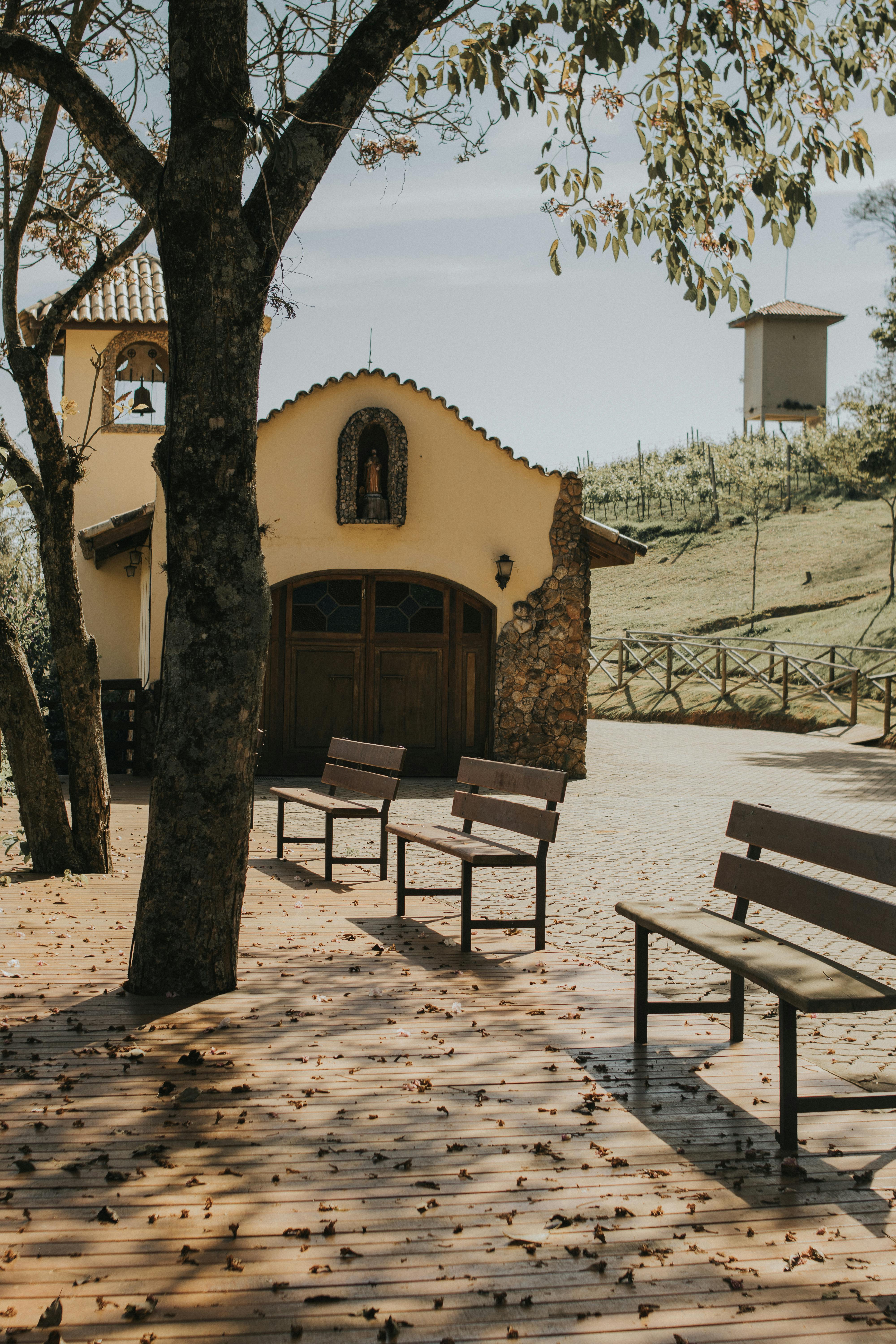 Charming Village Church with Rustic Benches · Free Stock Photo