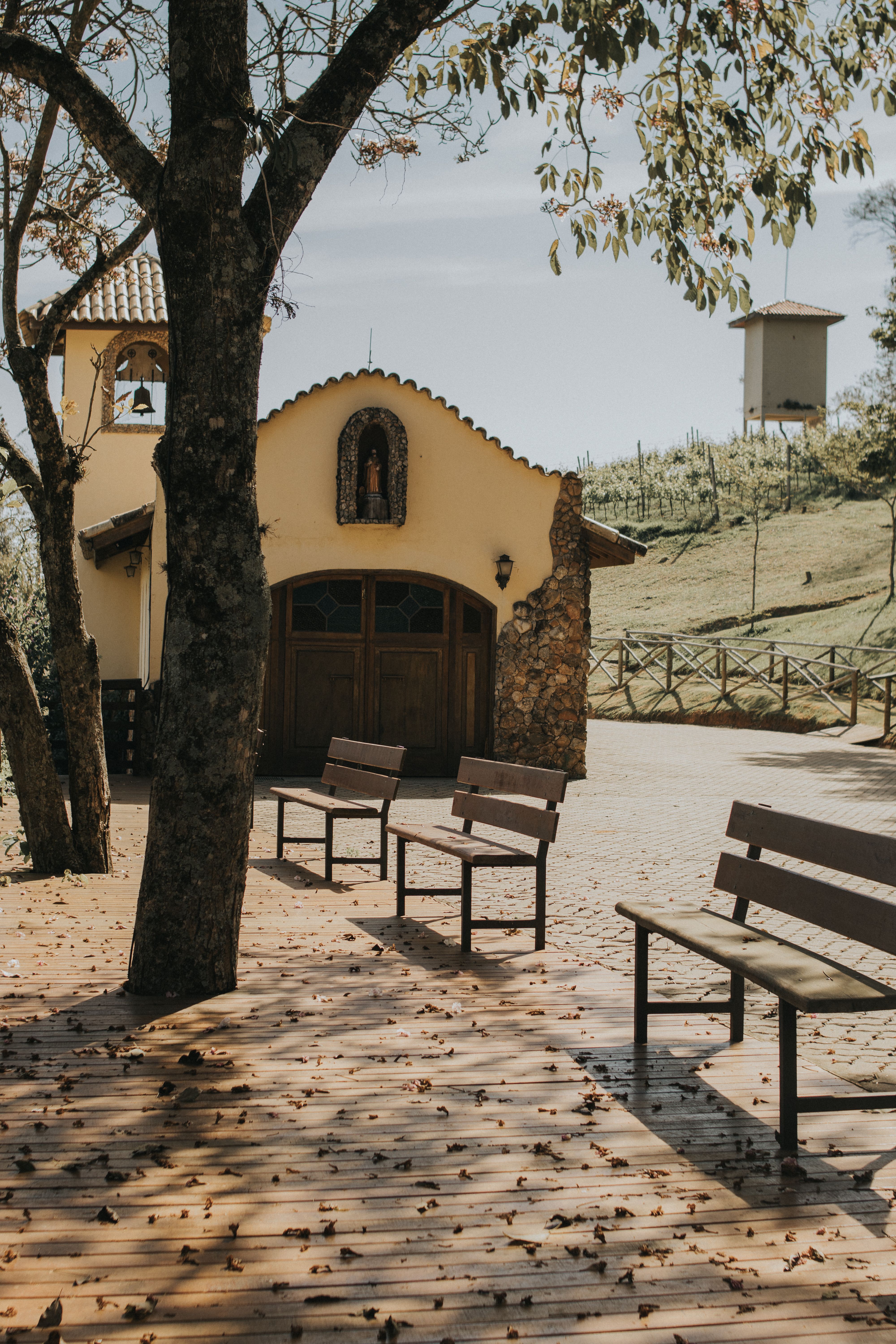 Charming Village Church with Rustic Benches · Free Stock Photo