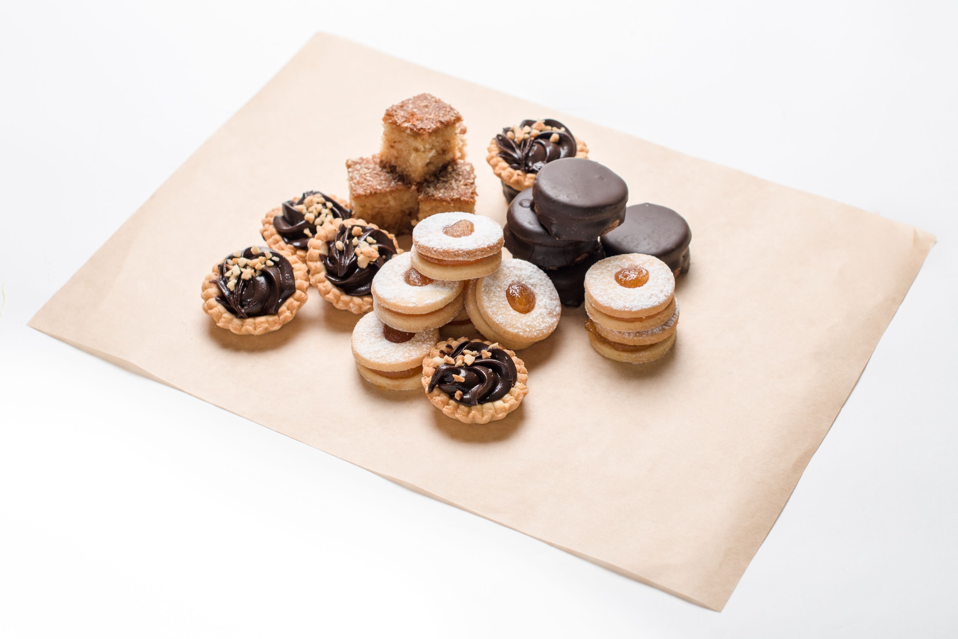 Assorted Sweet Pastries and Cookies on Parchment · Free Stock Photo