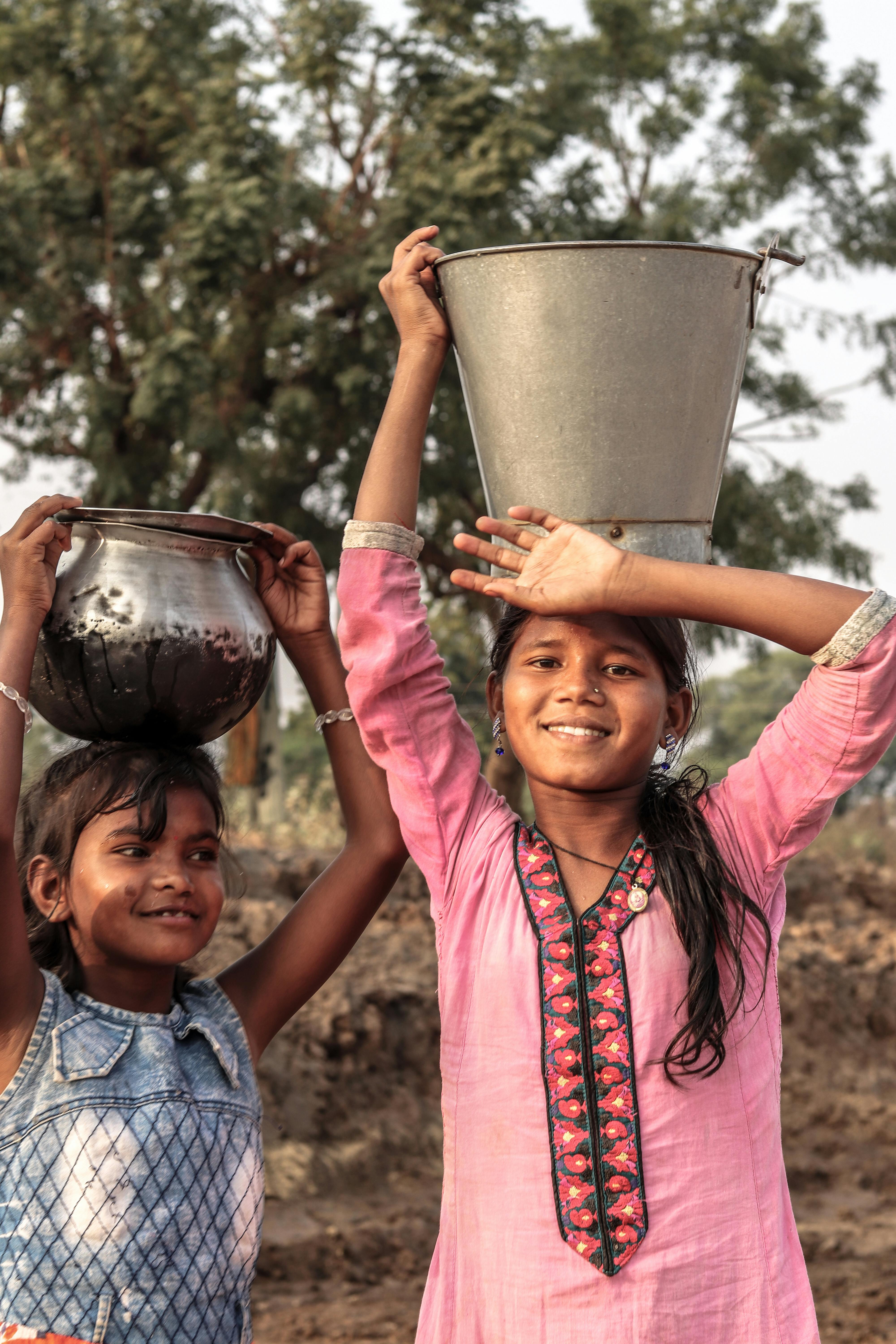 Two Asian Girls Carrying a Bucket · Free Stock Photo