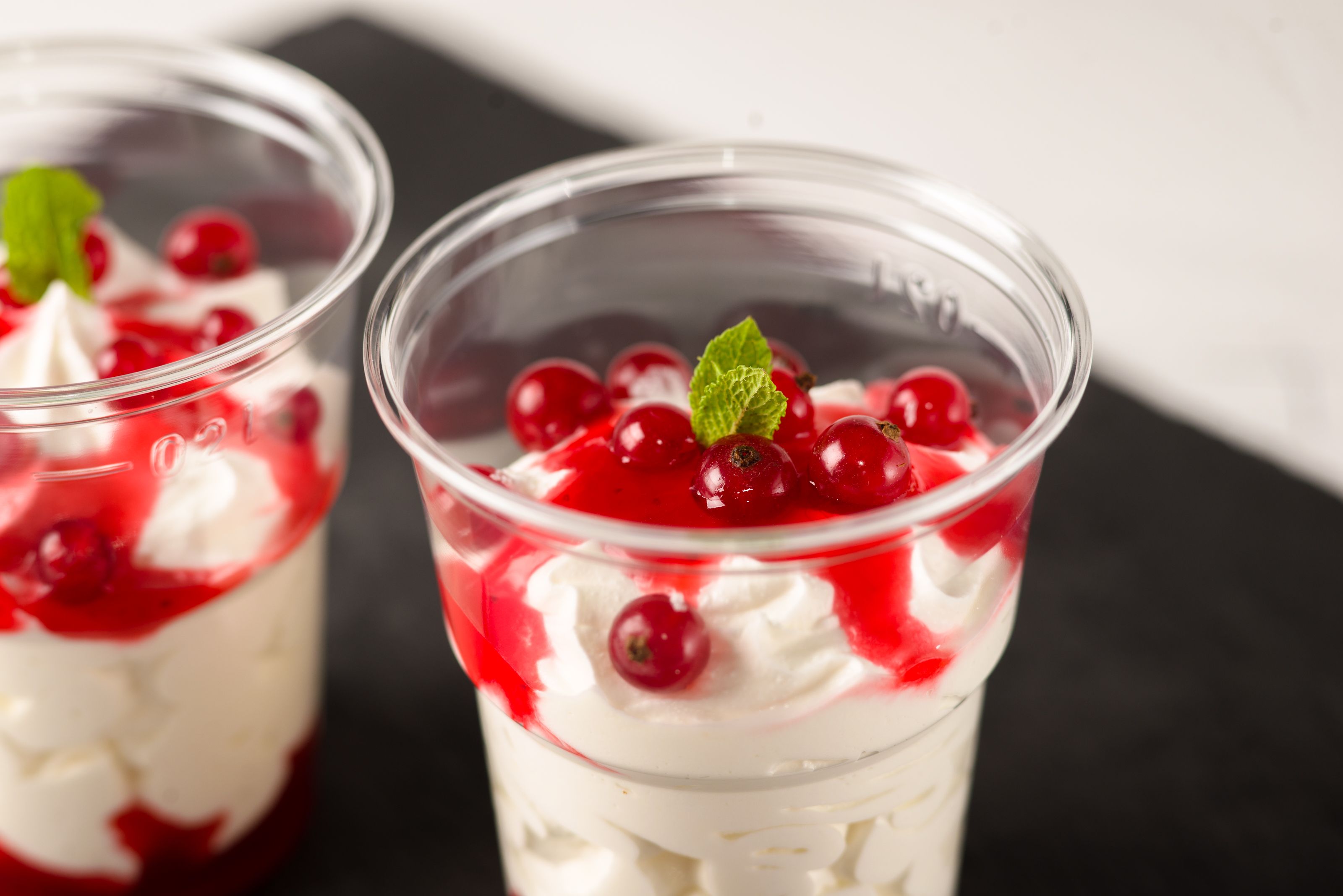 Delicious Berry and Cream Dessert in Plastic Cups · Free Stock Photo
