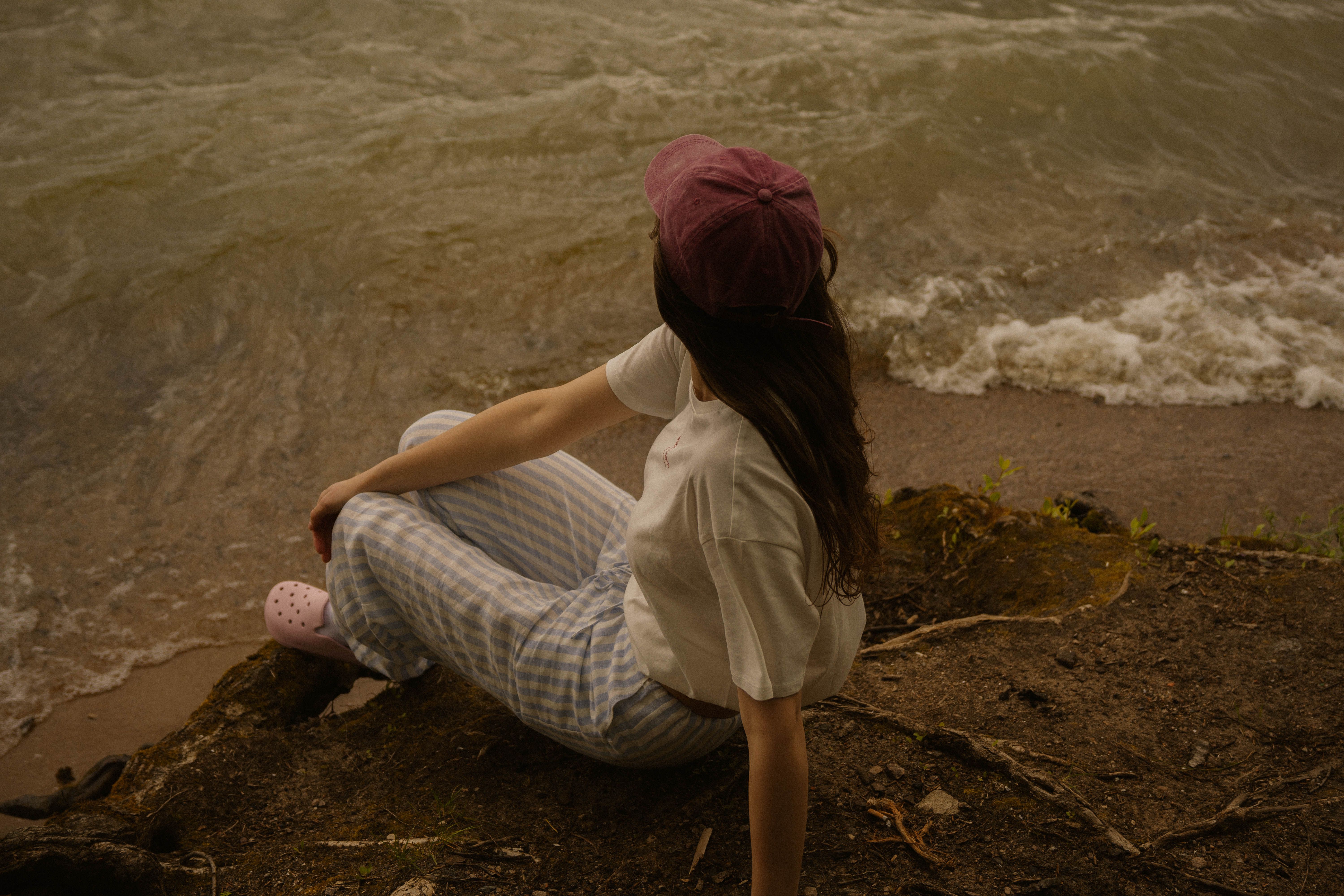Woman Sitting by the Shore with Waves · Free Stock Photo