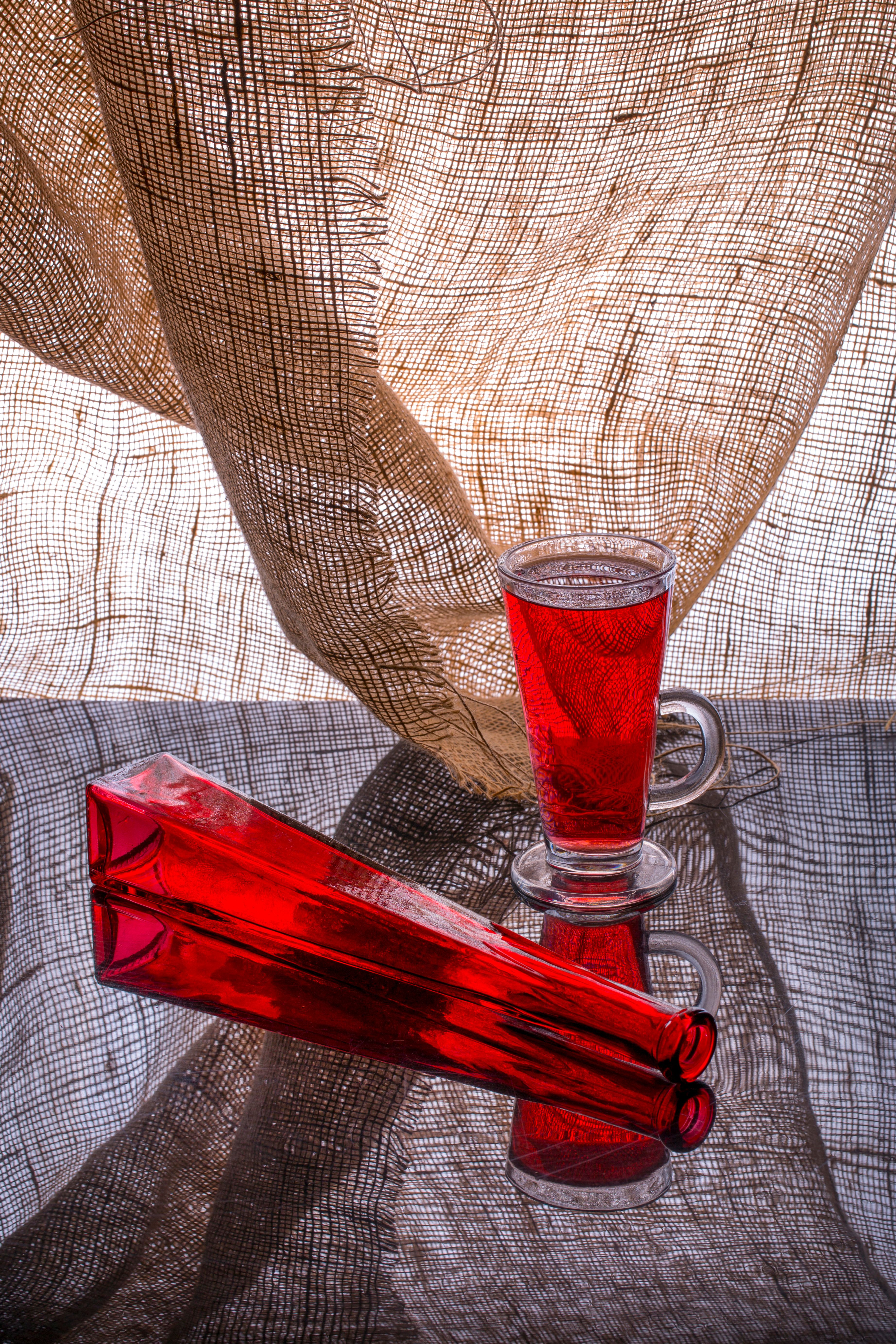 Red Beverage with Elegant Glass Bottle Reflection · Free Stock Photo