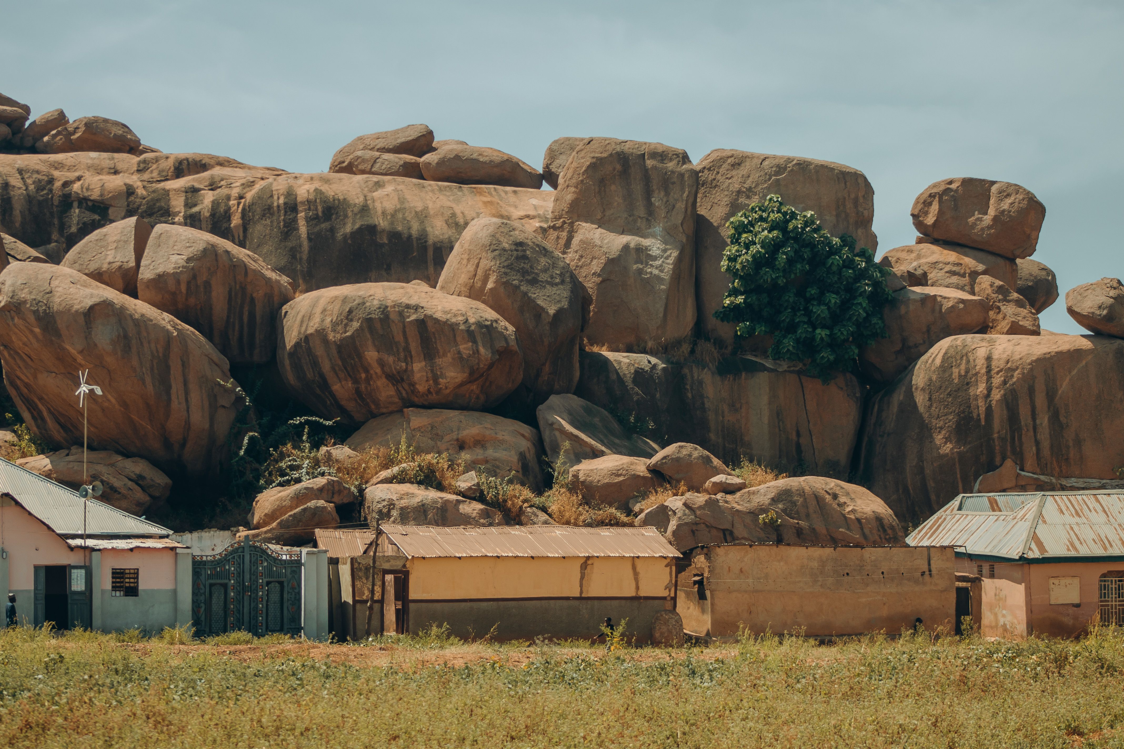 Rugged Rock Formations Behind Rural Homes · Free Stock Photo