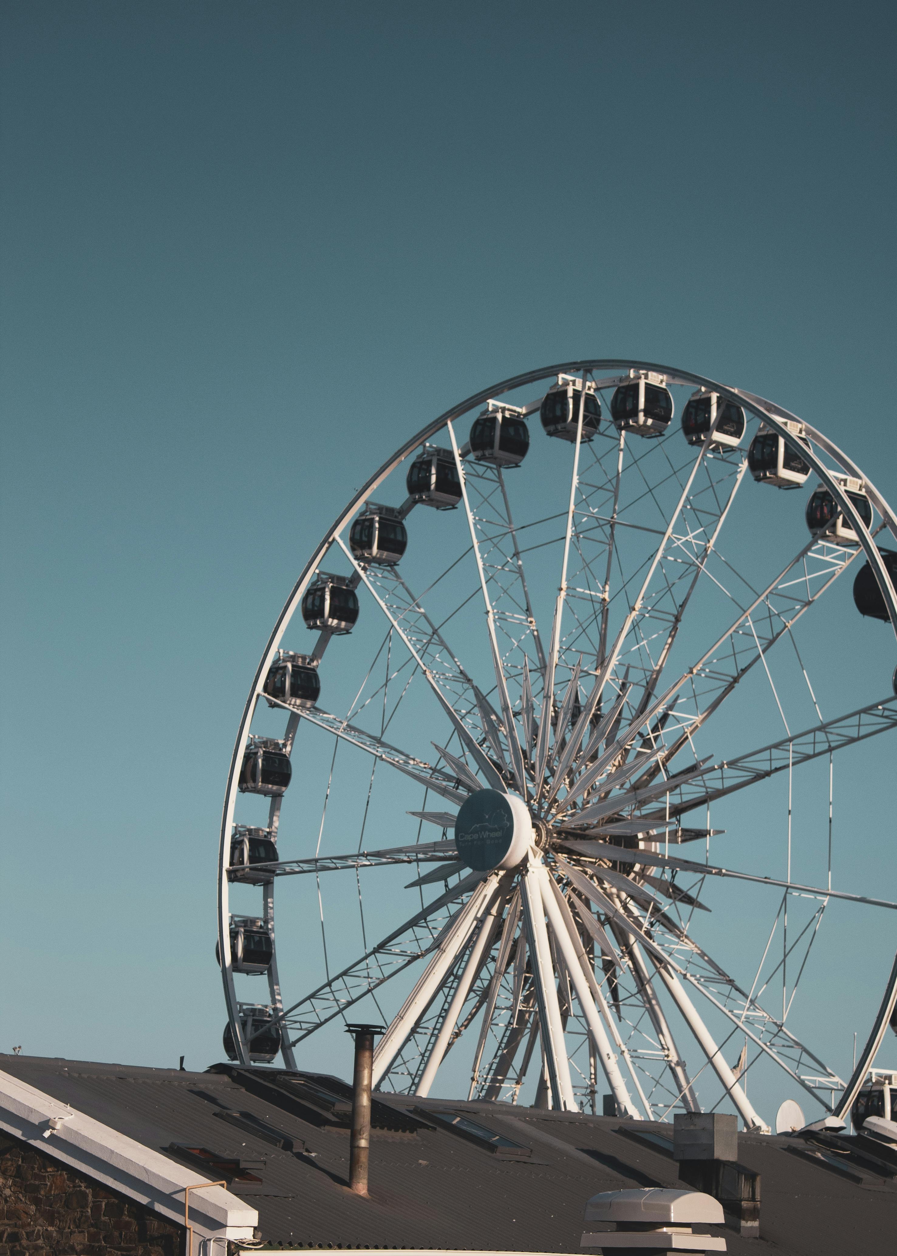 Ferris wheel above building in city park · Free Stock Photo