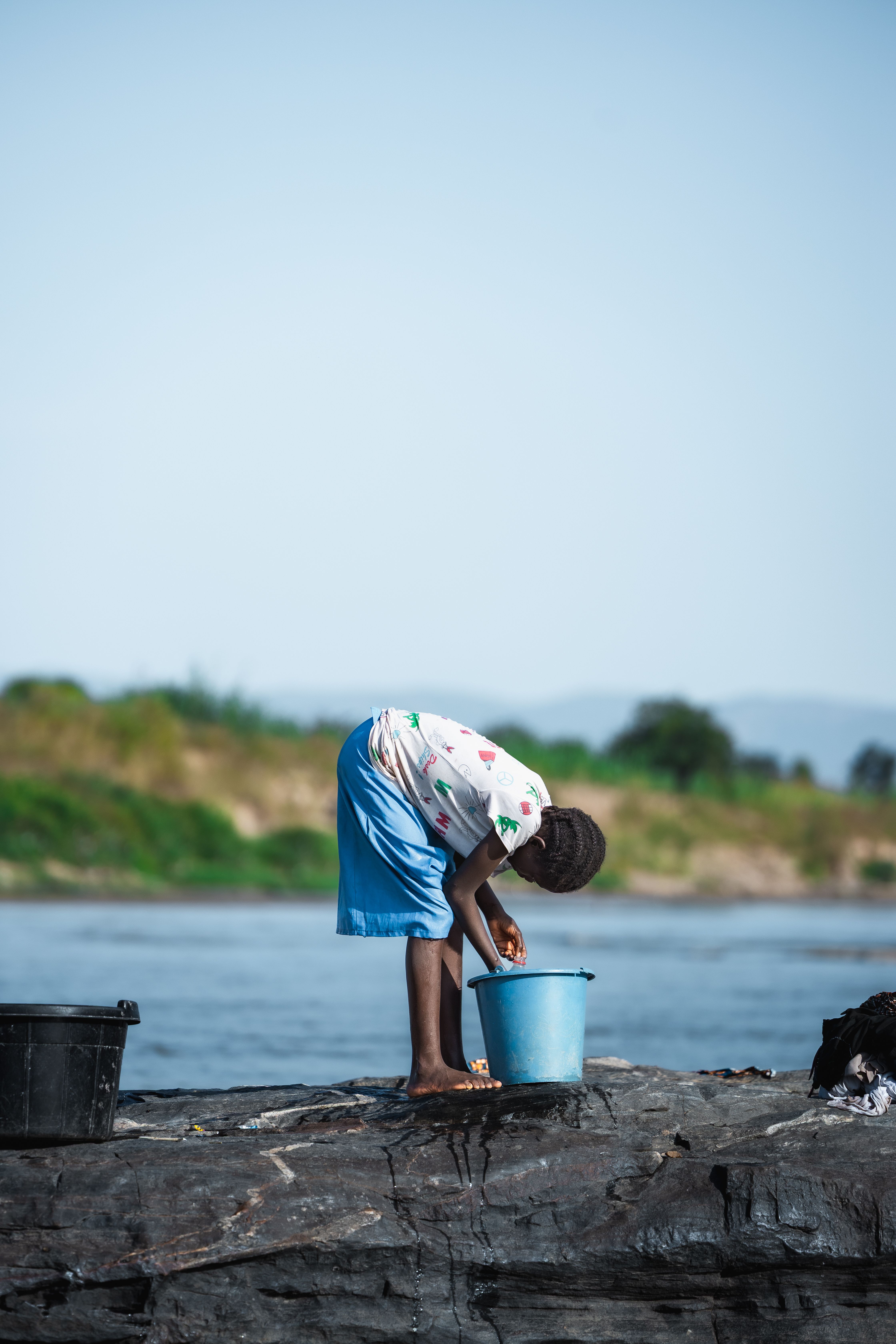 Young African Girl Washing by the River · Free Stock Photo