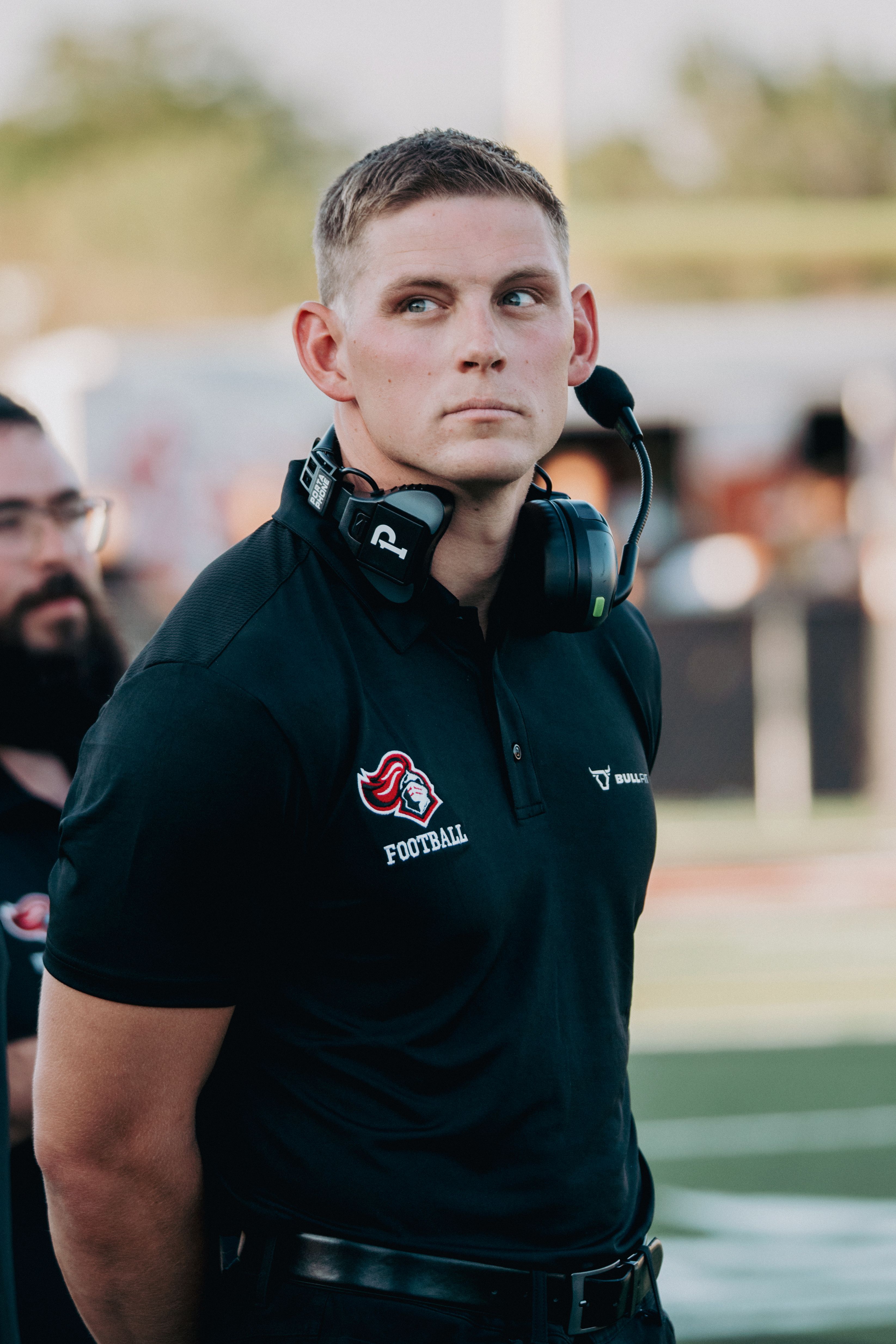 Focused Football Coach on Sideline at Game · Free Stock Photo