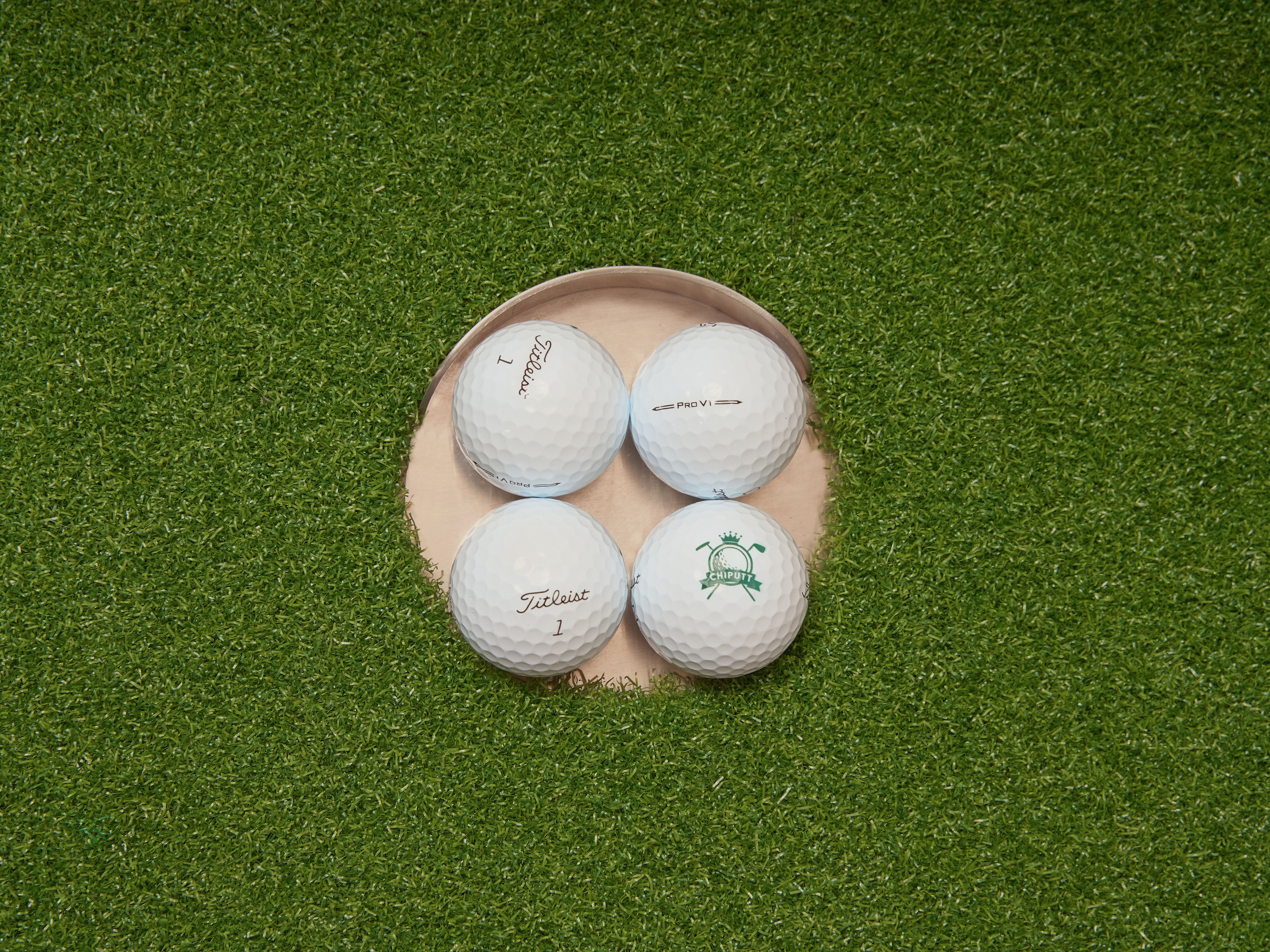 Golf Balls in the Hole on Artificial Turf Green · Free Stock Photo