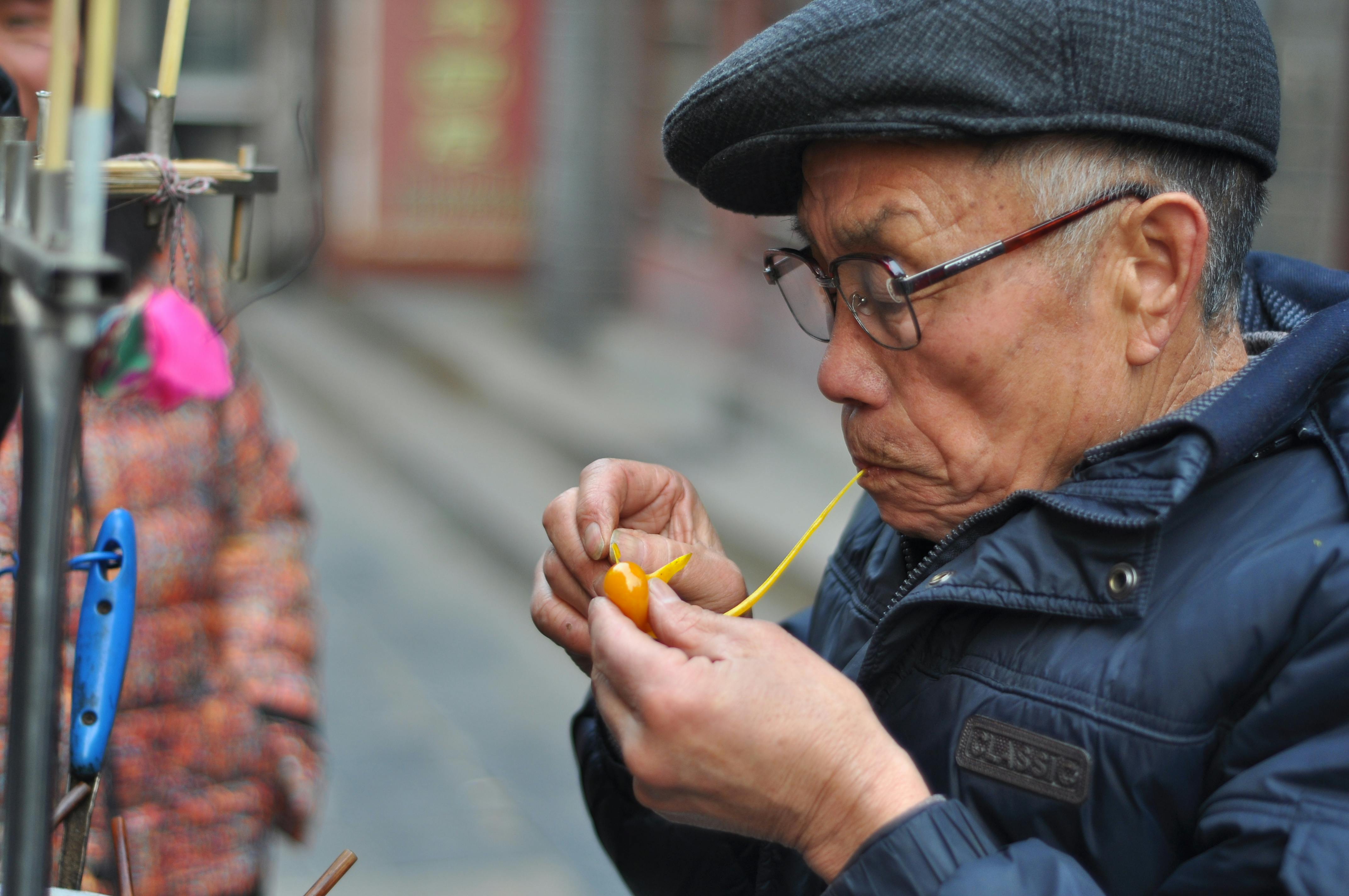 Traditional Street Food Vendor Blowing Sugar Art · Free Stock Photo