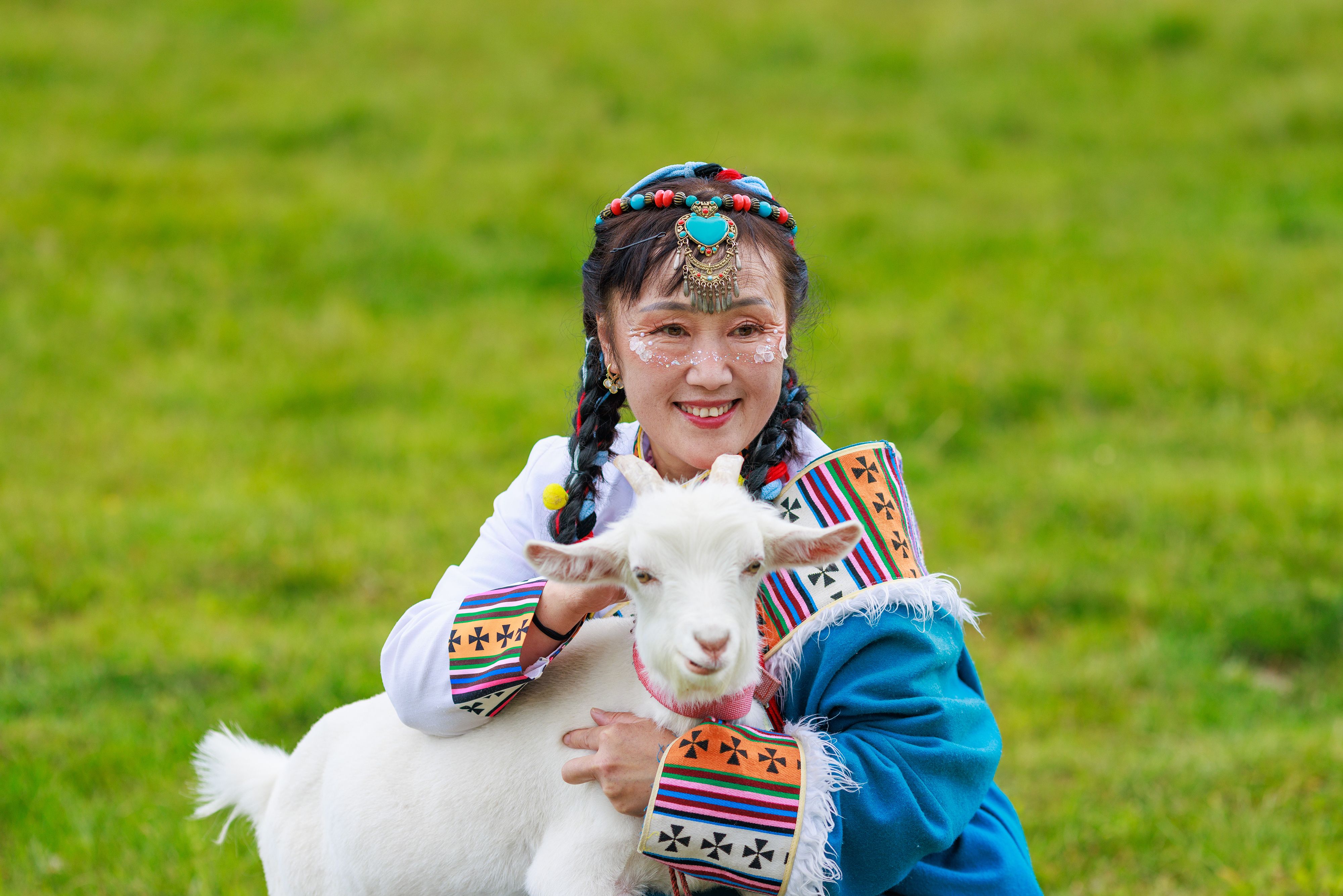 Woman in Traditional Attire with White Goat Outdoors · Free Stock Photo