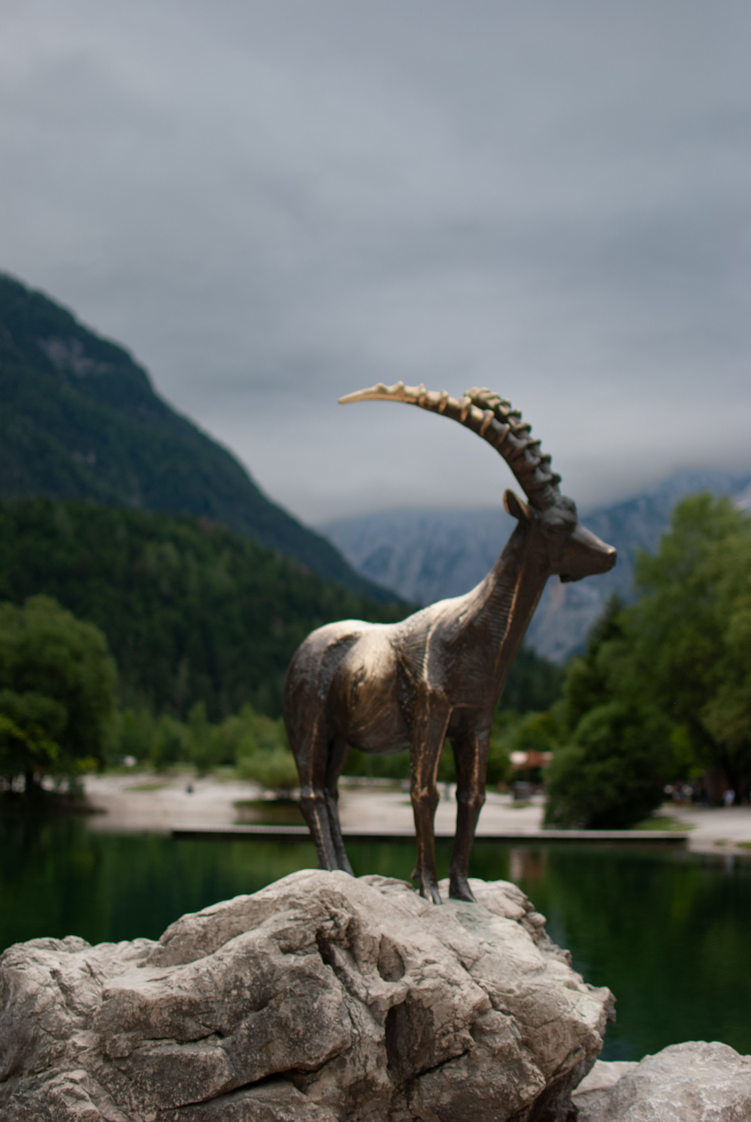 Bronze Ibex Statue by Lake in Alpine Landscape · Free Stock Photo
