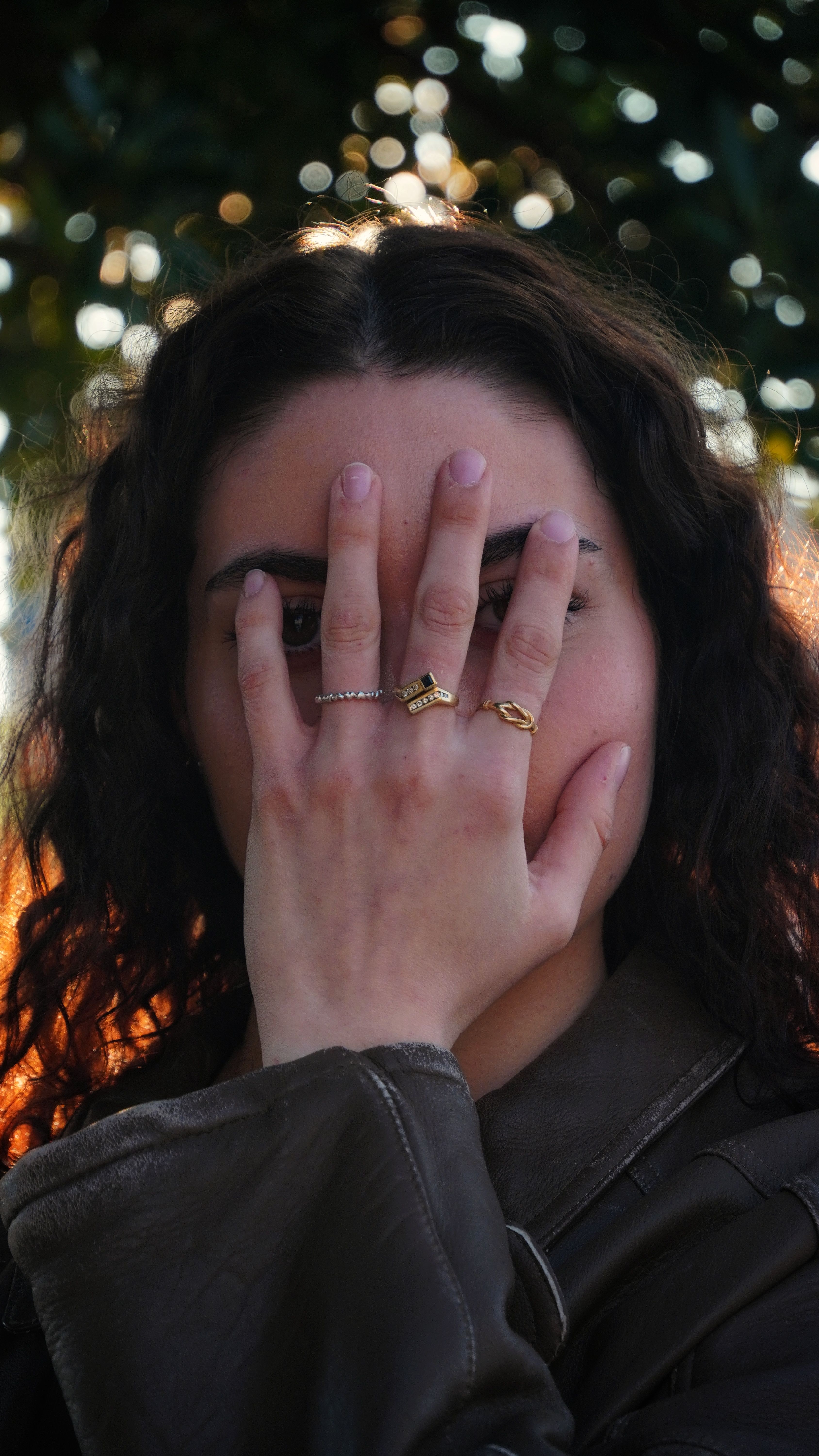 Woman Covering Face with Rings in Outdoor Setting · Free Stock Photo