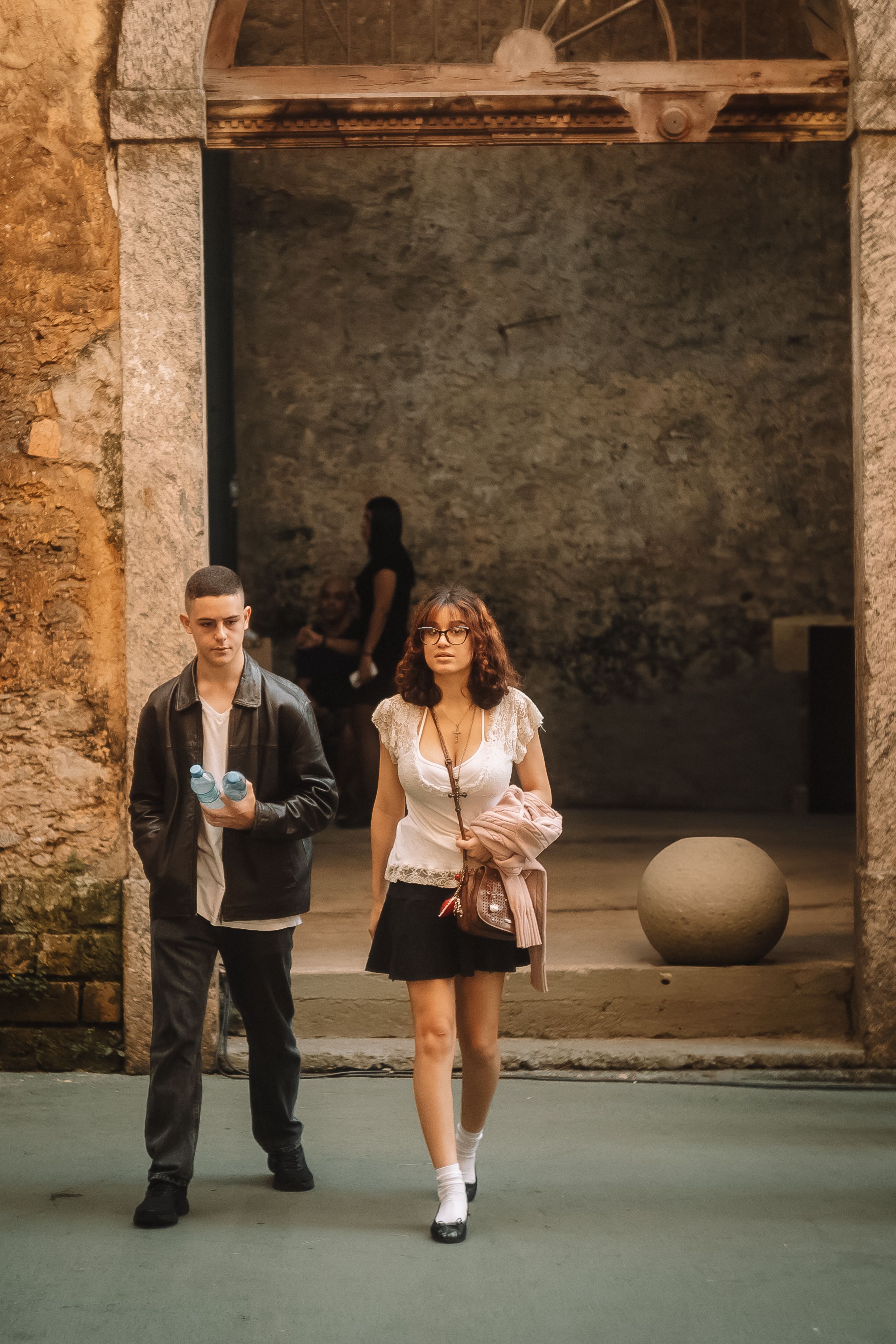 Young Adults Walking Through Historic Archway · Free Stock Photo