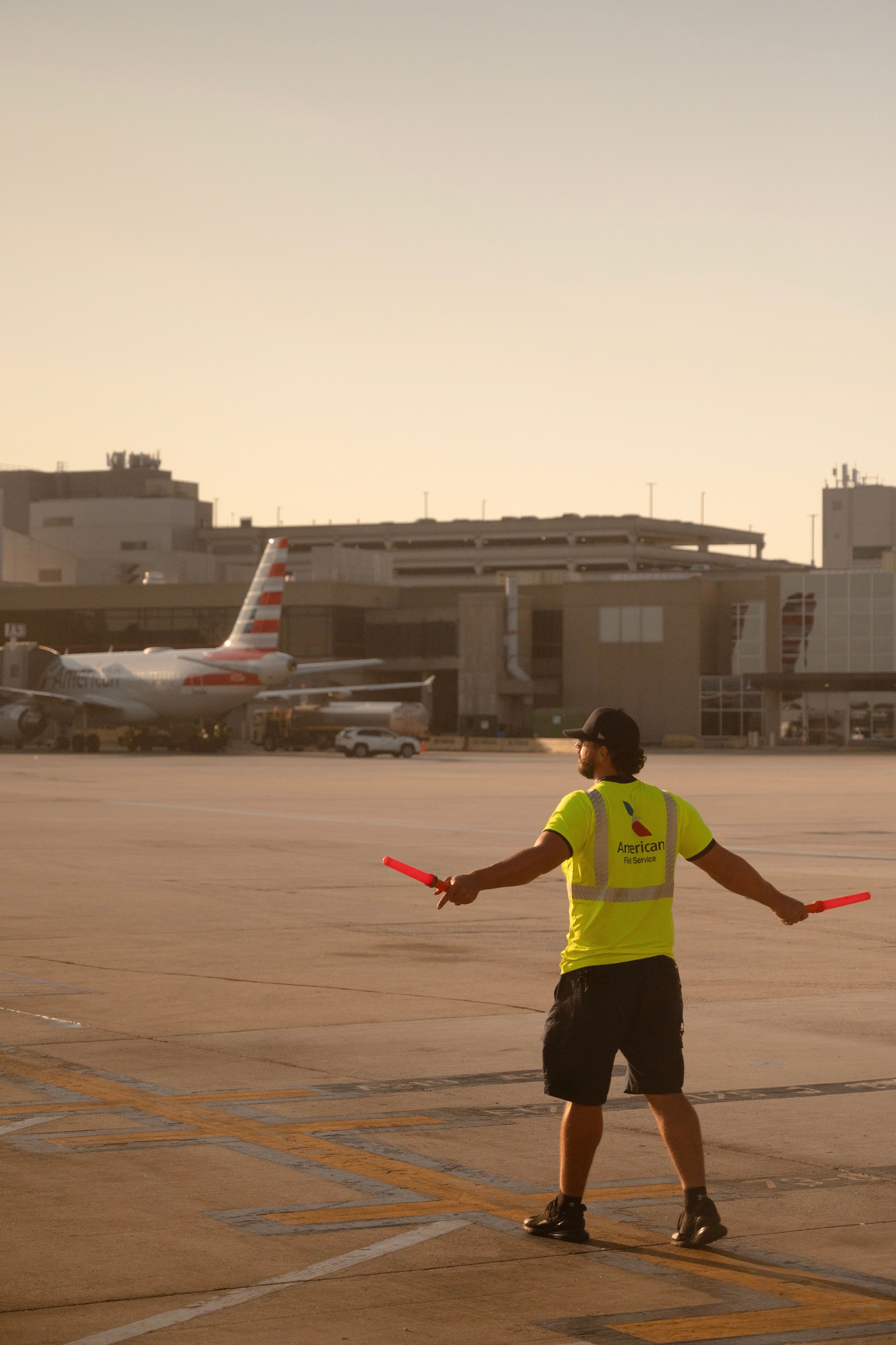Airport Worker Directing Plane During Sunset · Free Stock Photo