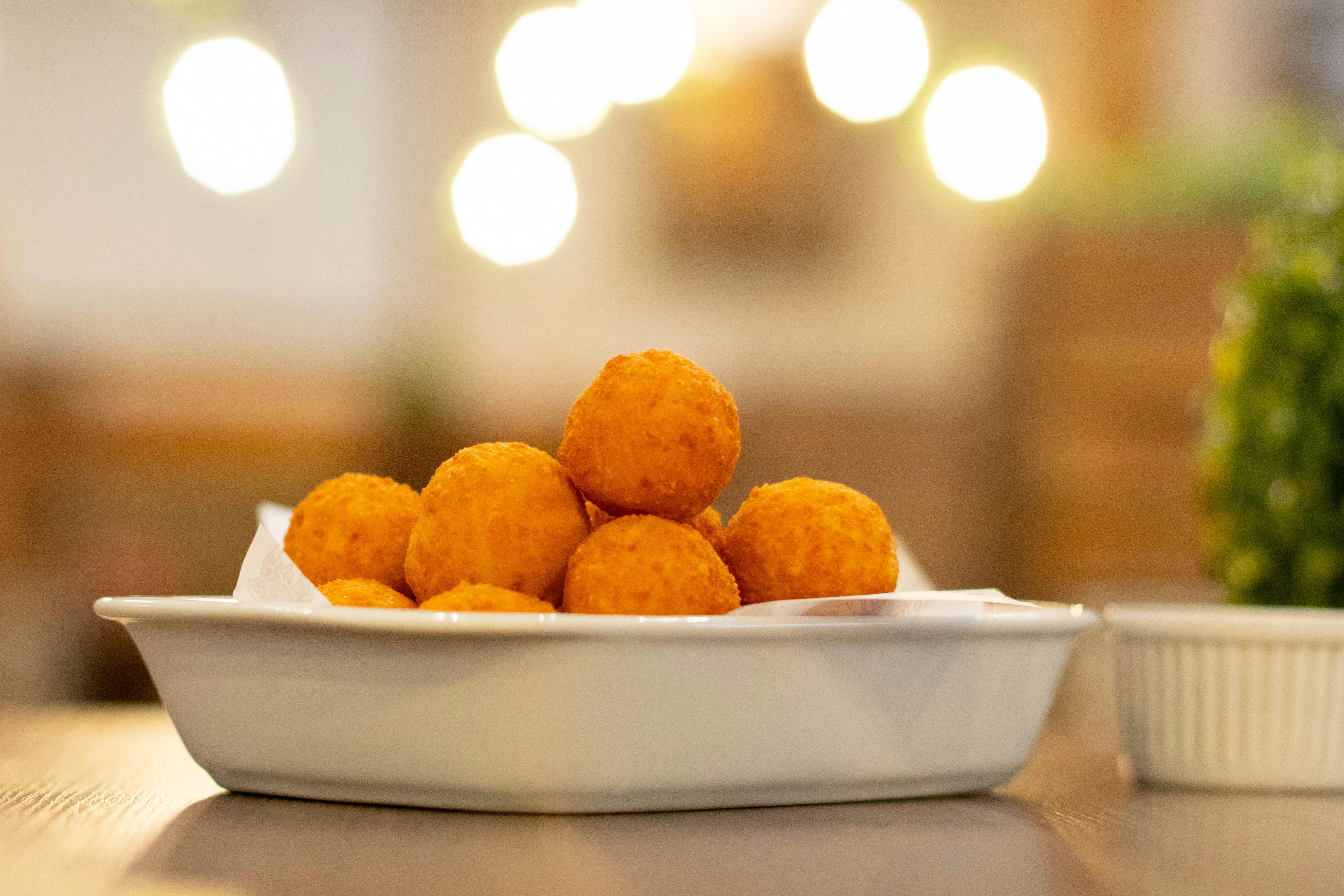 Golden Cheese Balls in White Dish on Wooden Table · Free Stock Photo
