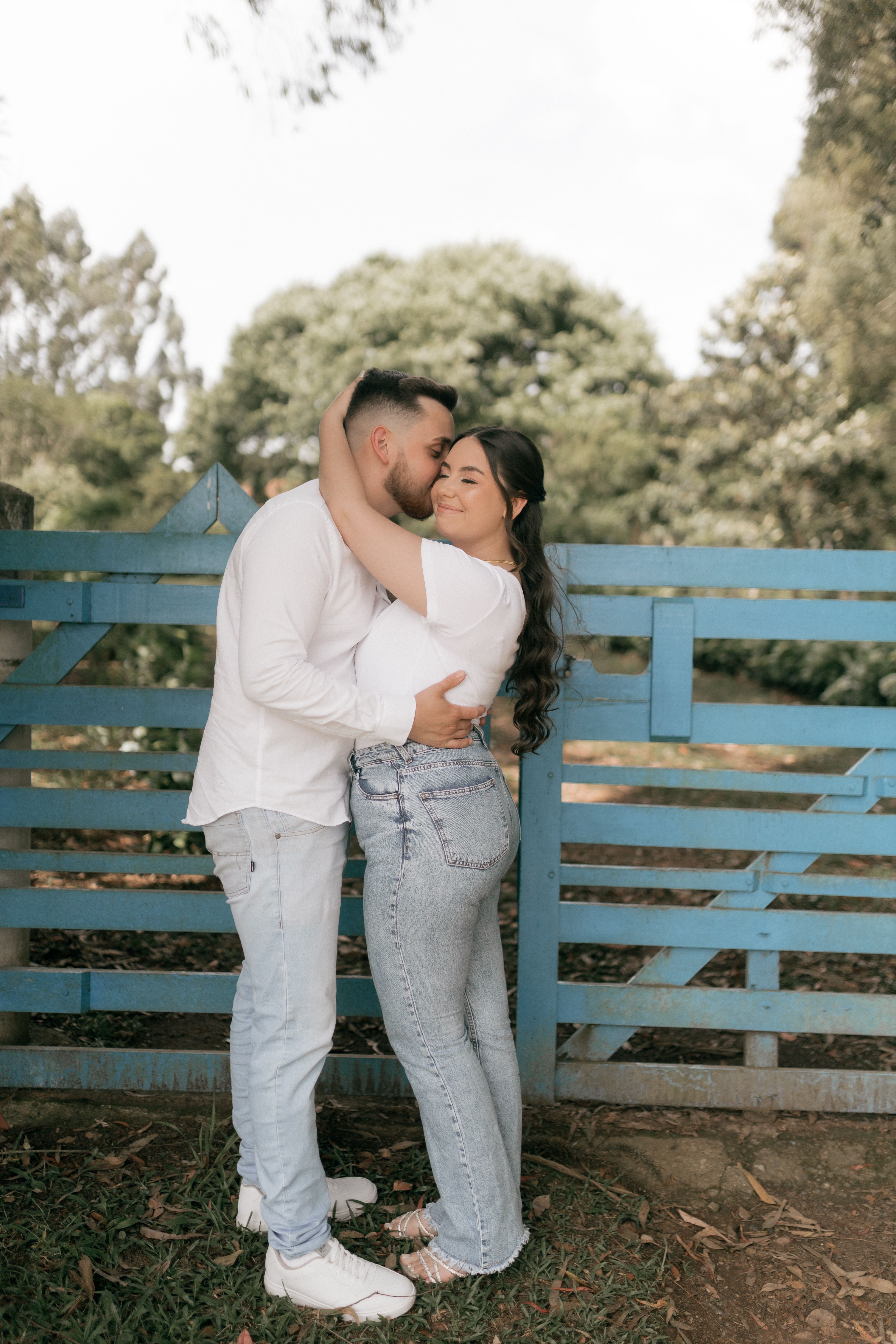 Romantic Couple Embracing by Blue Fence Outdoors · Free Stock Photo