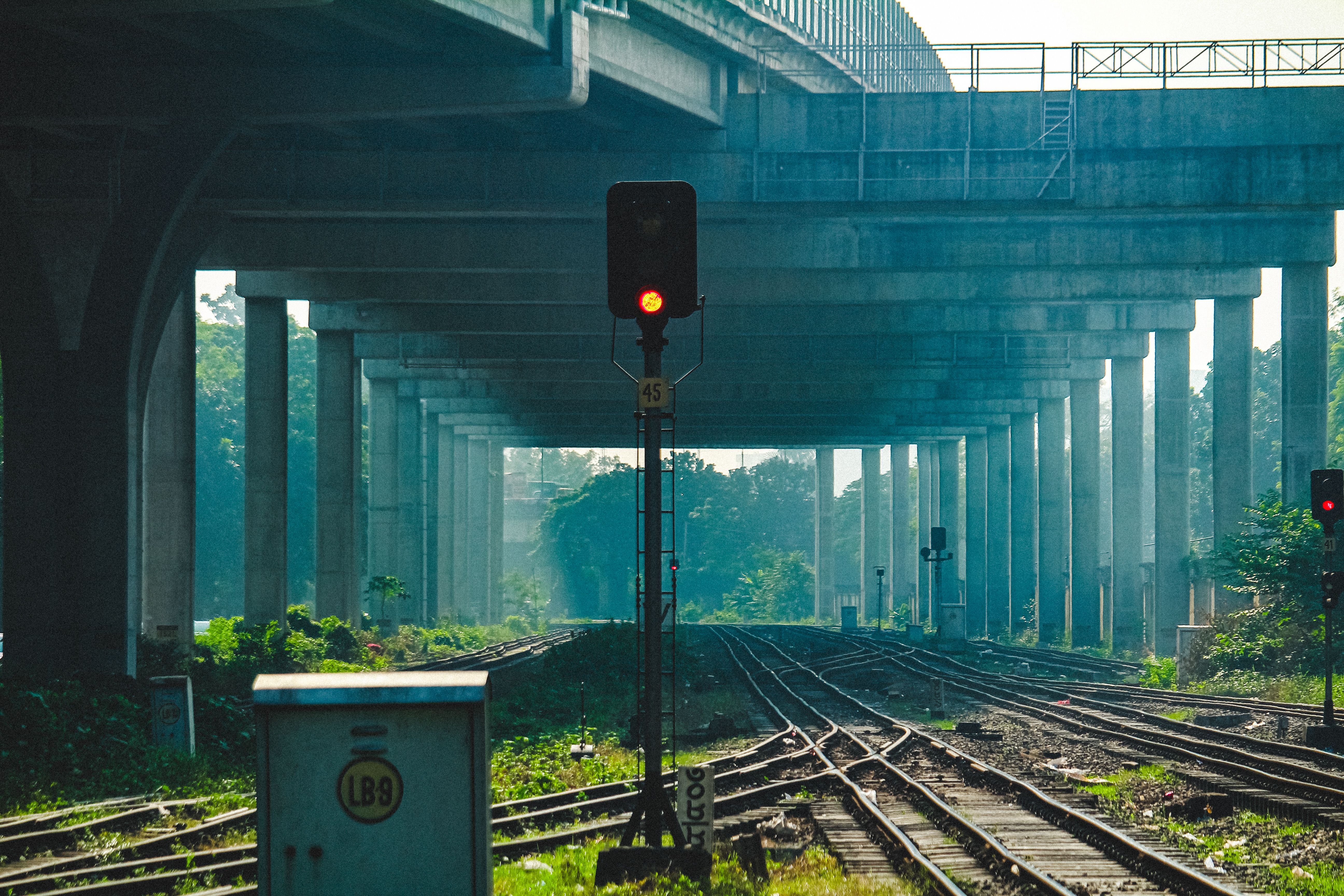 Urban railroad under concrete bridge · Free Stock Photo