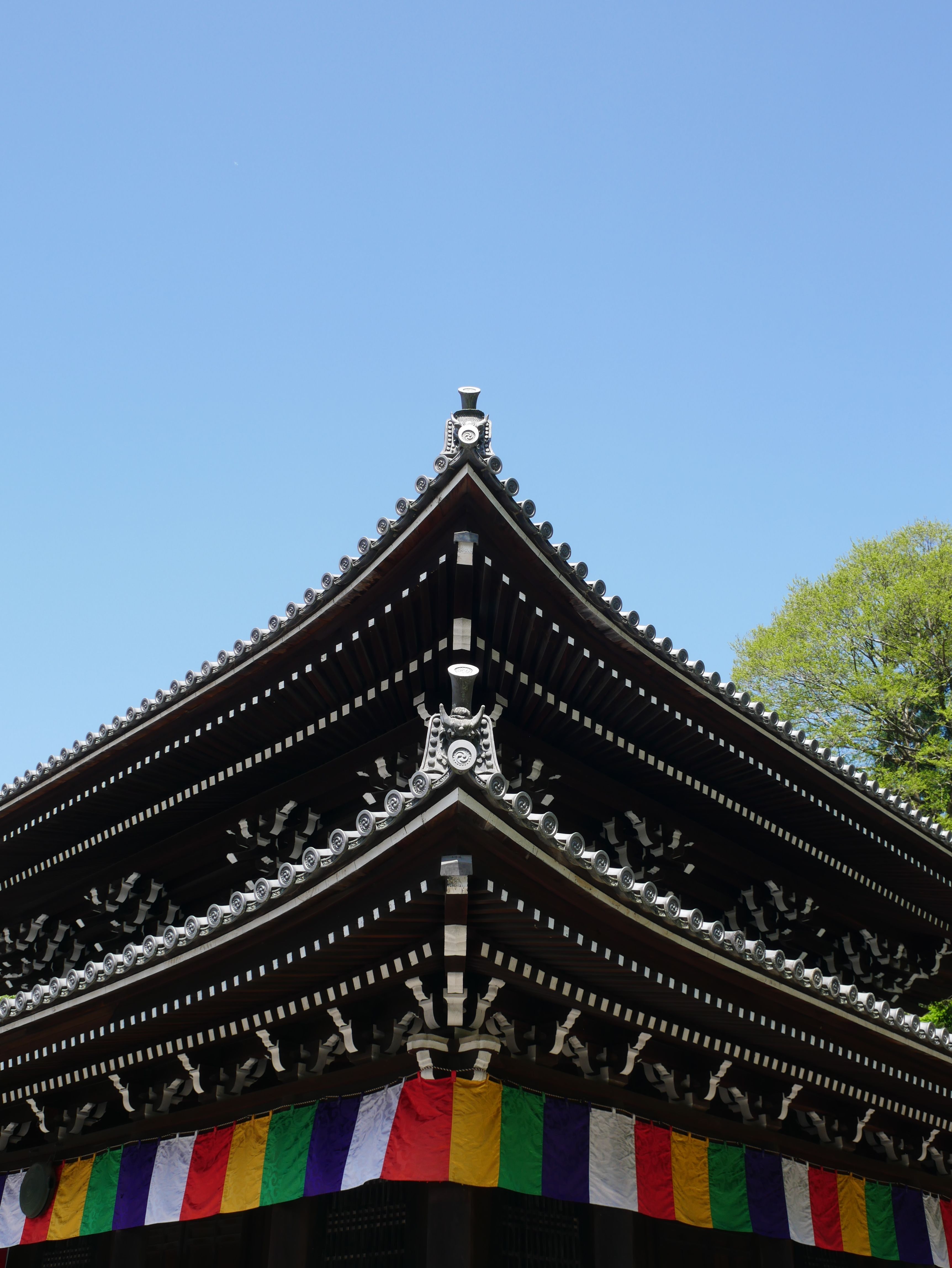Traditional Japanese Temple Roof Under Clear Sky · Free Stock Photo