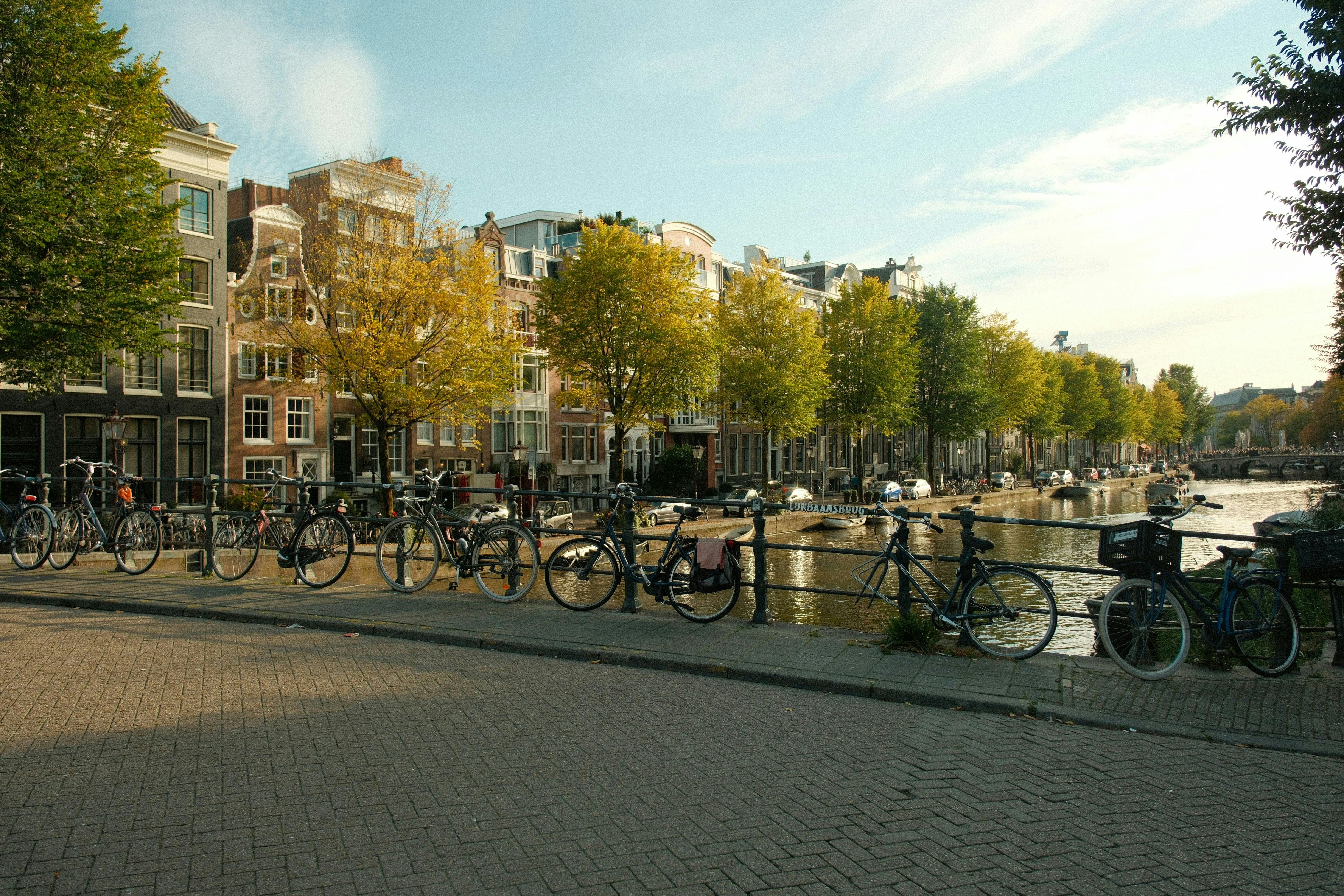 Amsterdam canal lined with bicycles and autumn trees on a sunny day