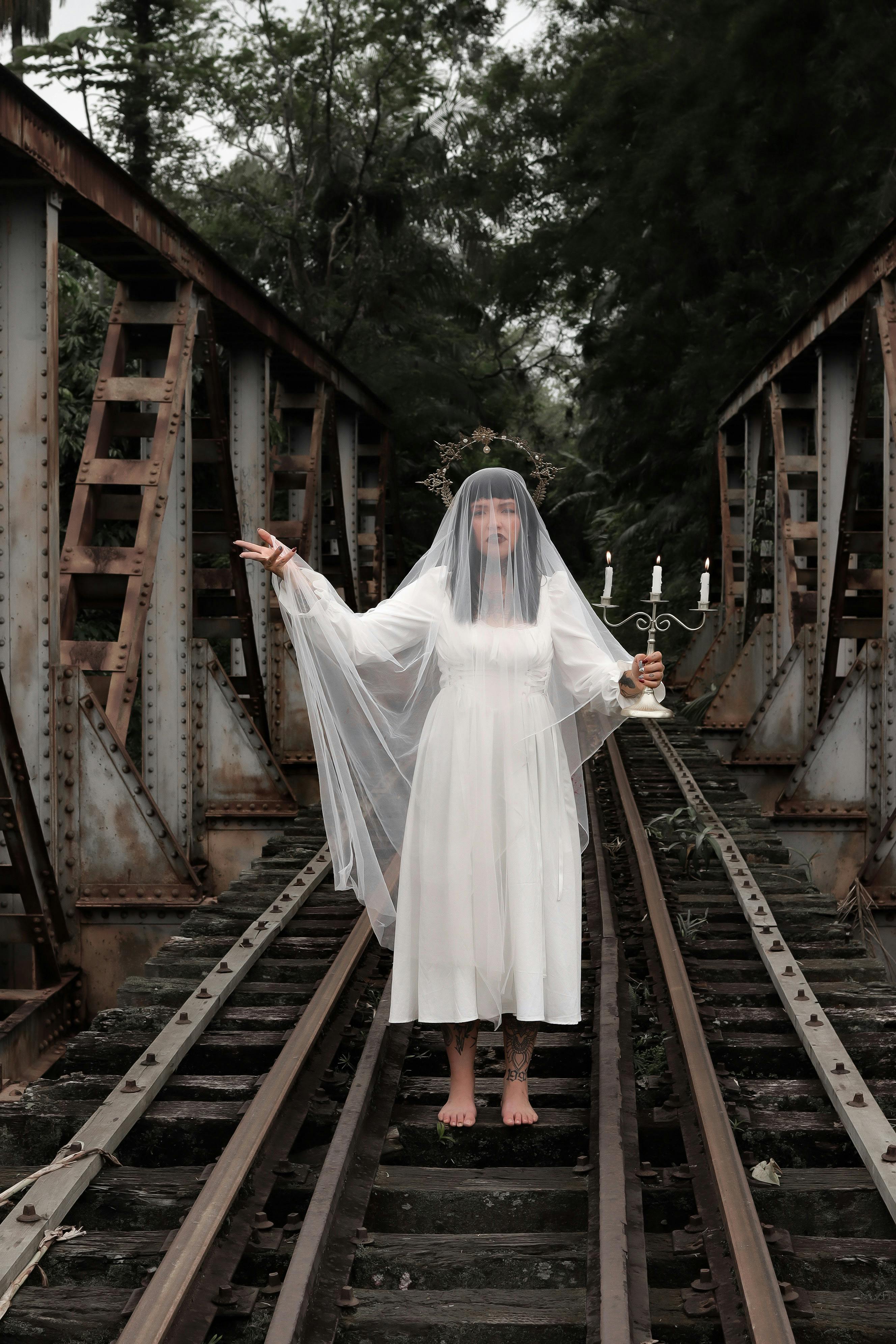 Ethereal Woman in White on Railway Bridge · Free Stock Photo