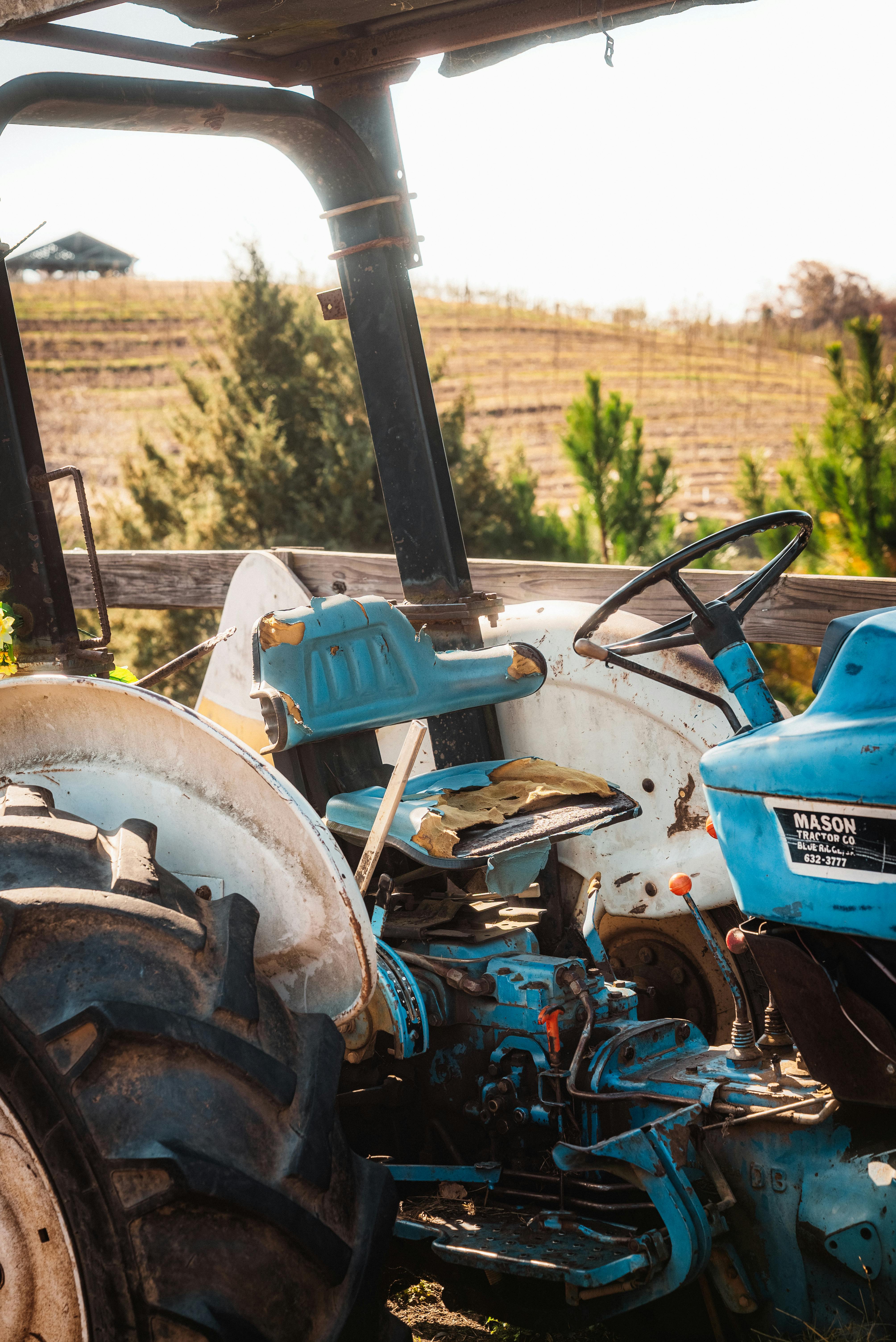 Vintage Blue Tractor in Scenic Farmland Landscape · Free Stock Photo