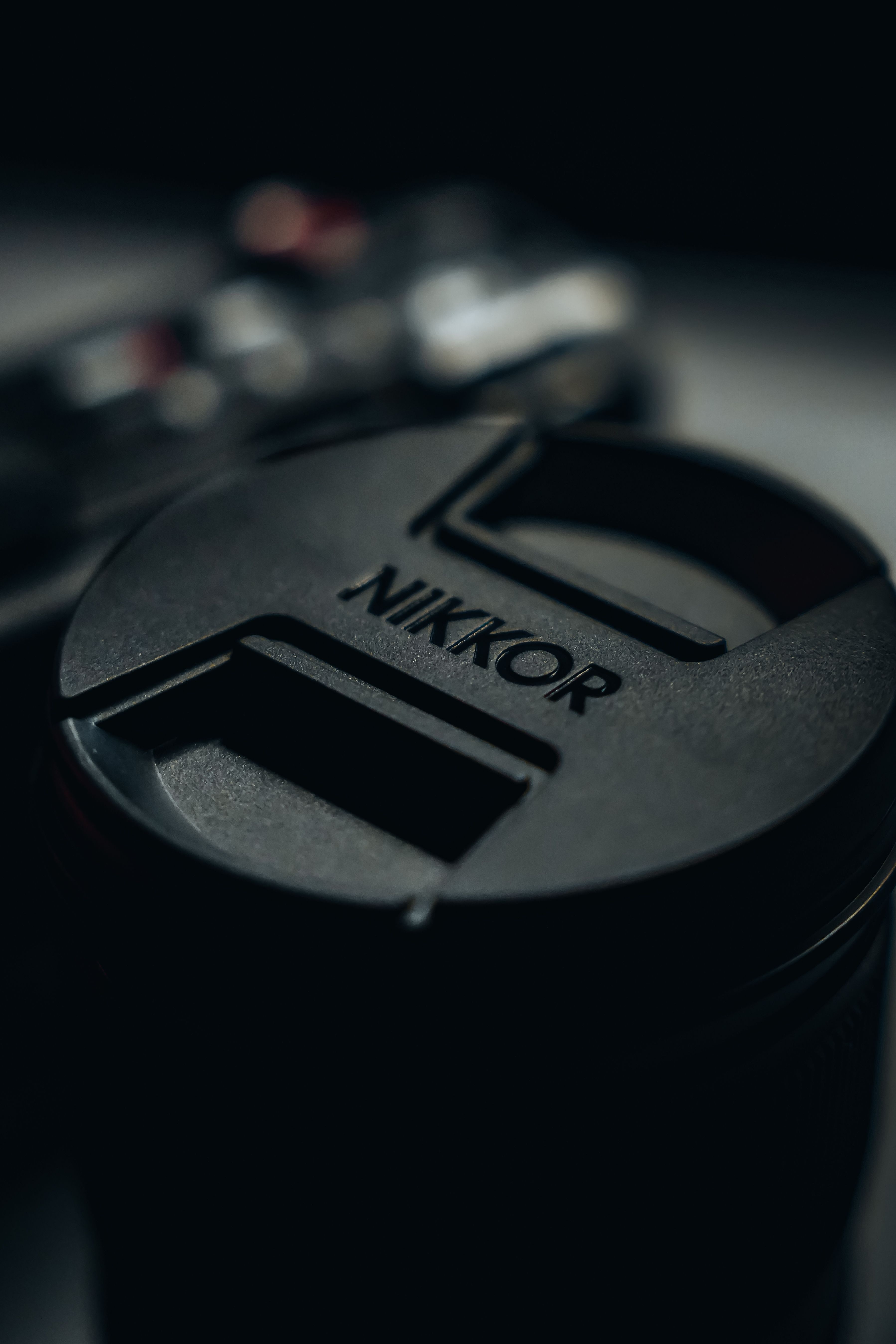 Close-up of Nikkor Camera Lens Cap in Moody Lighting · Free Stock Photo