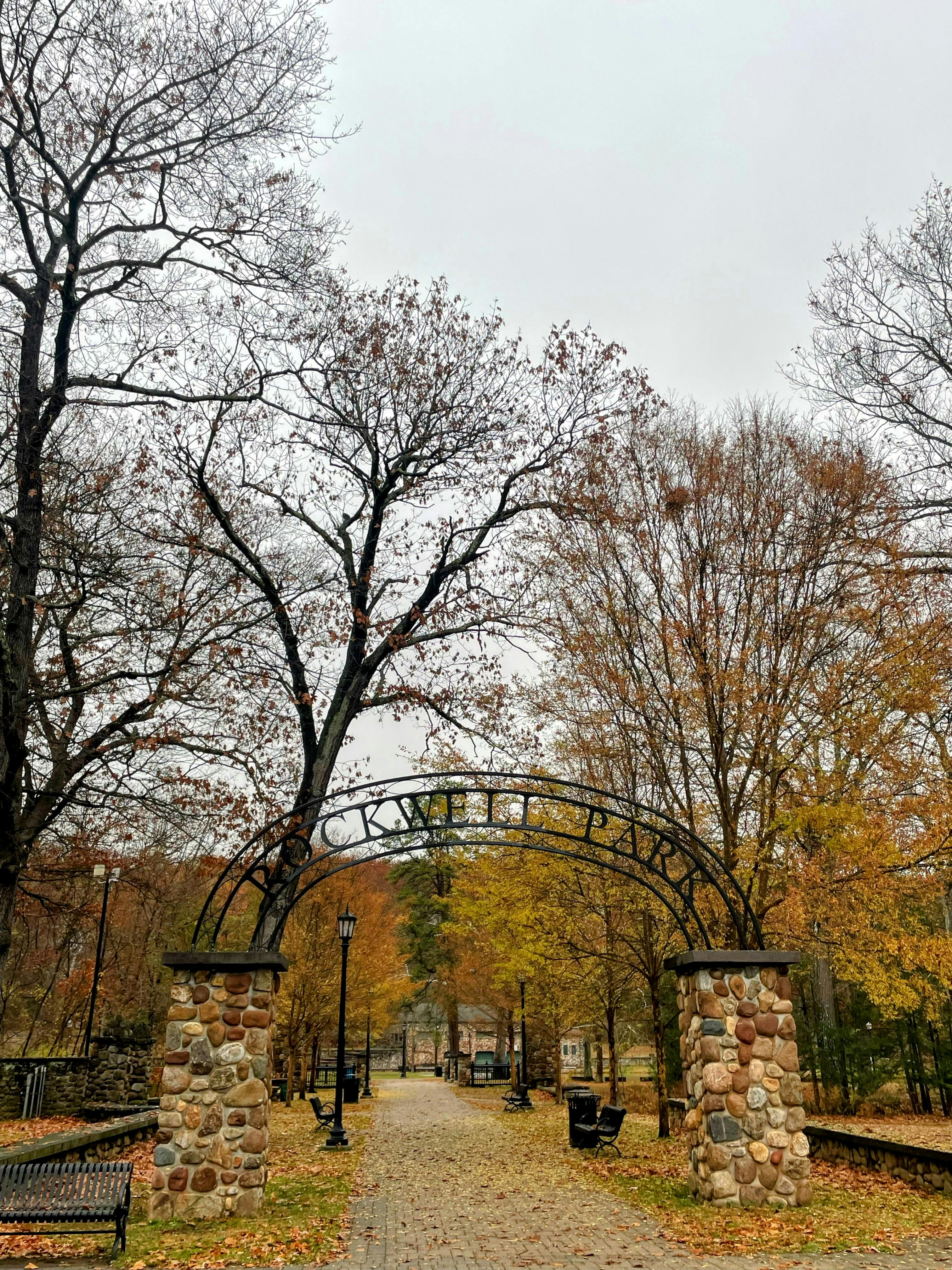 Autumn Pathway Under Stone Archway in Park · Free Stock Photo