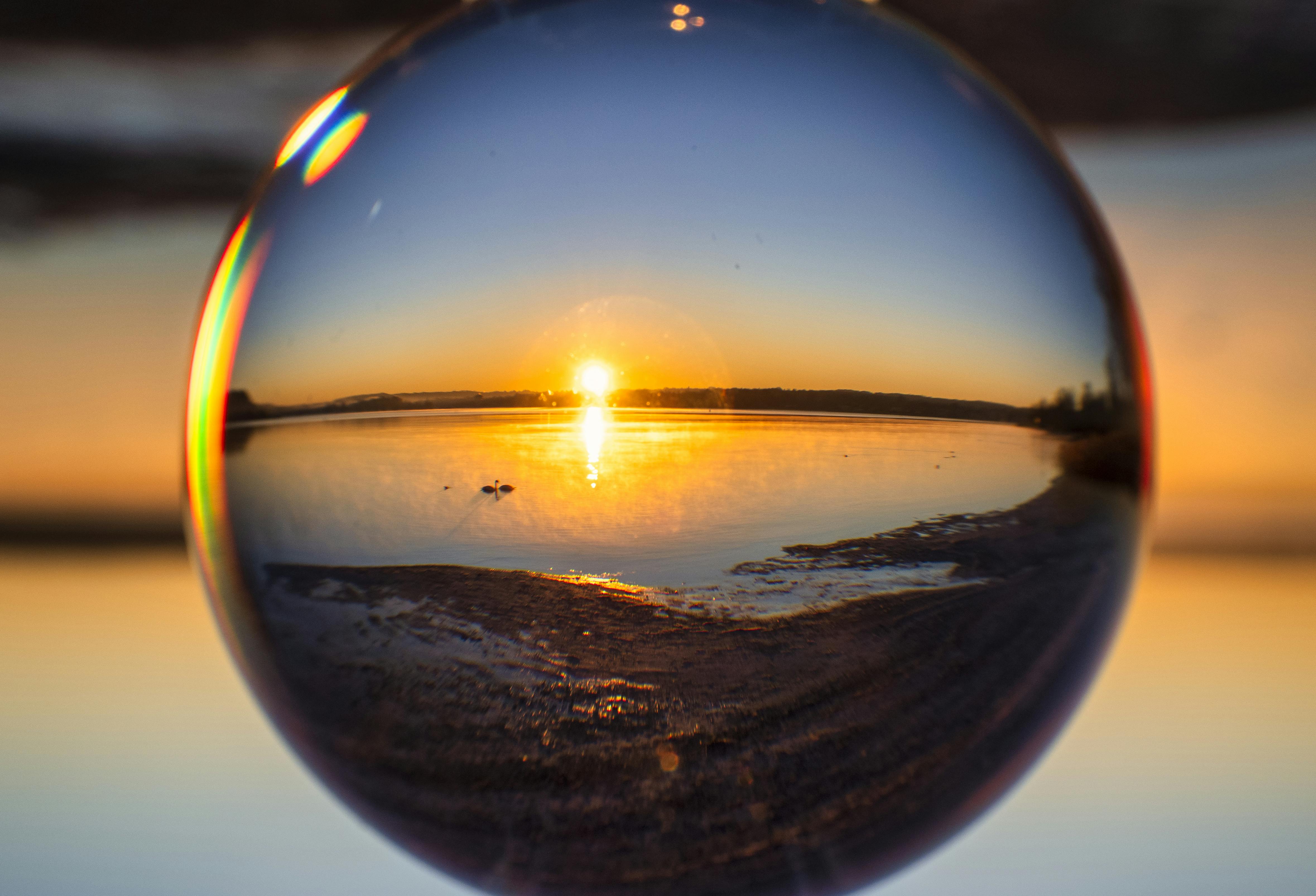 Surreal Sunset Reflection Through Glass Sphere · Free Stock Photo