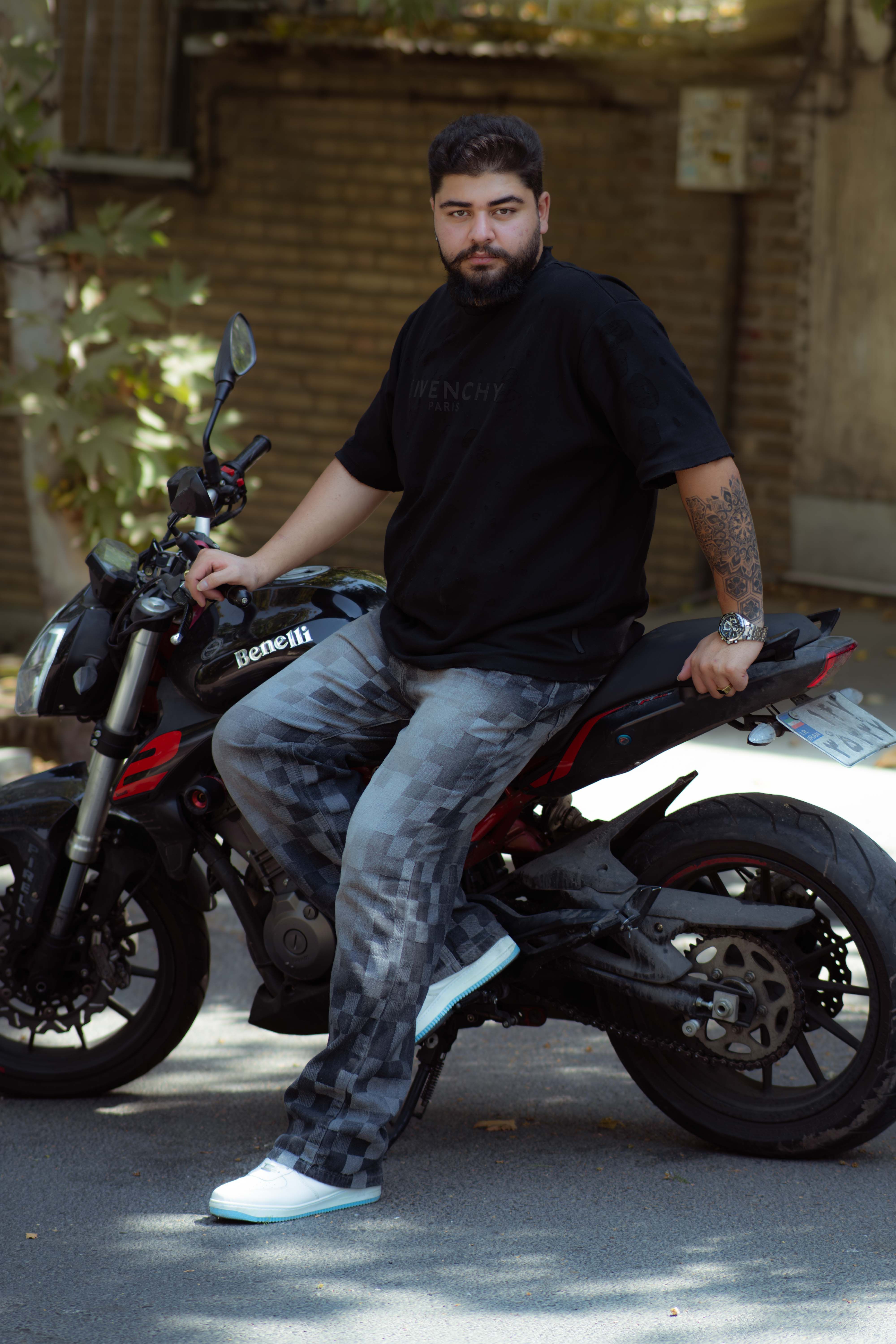 Man Posing on Motorcycle in Urban Tehran Setting · Free Stock Photo