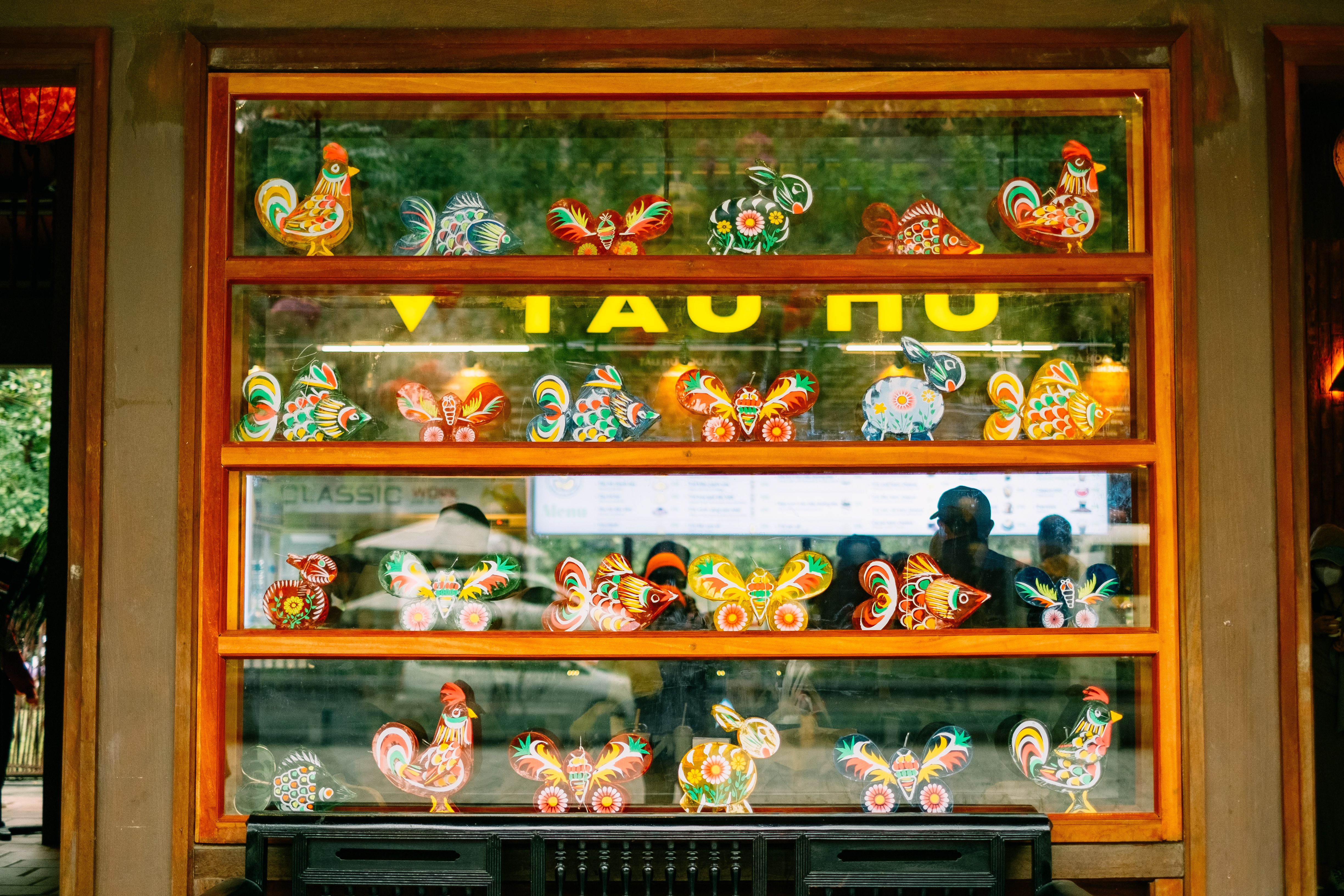 Vibrant handmade crafts displayed in shop window · Free Stock Photo