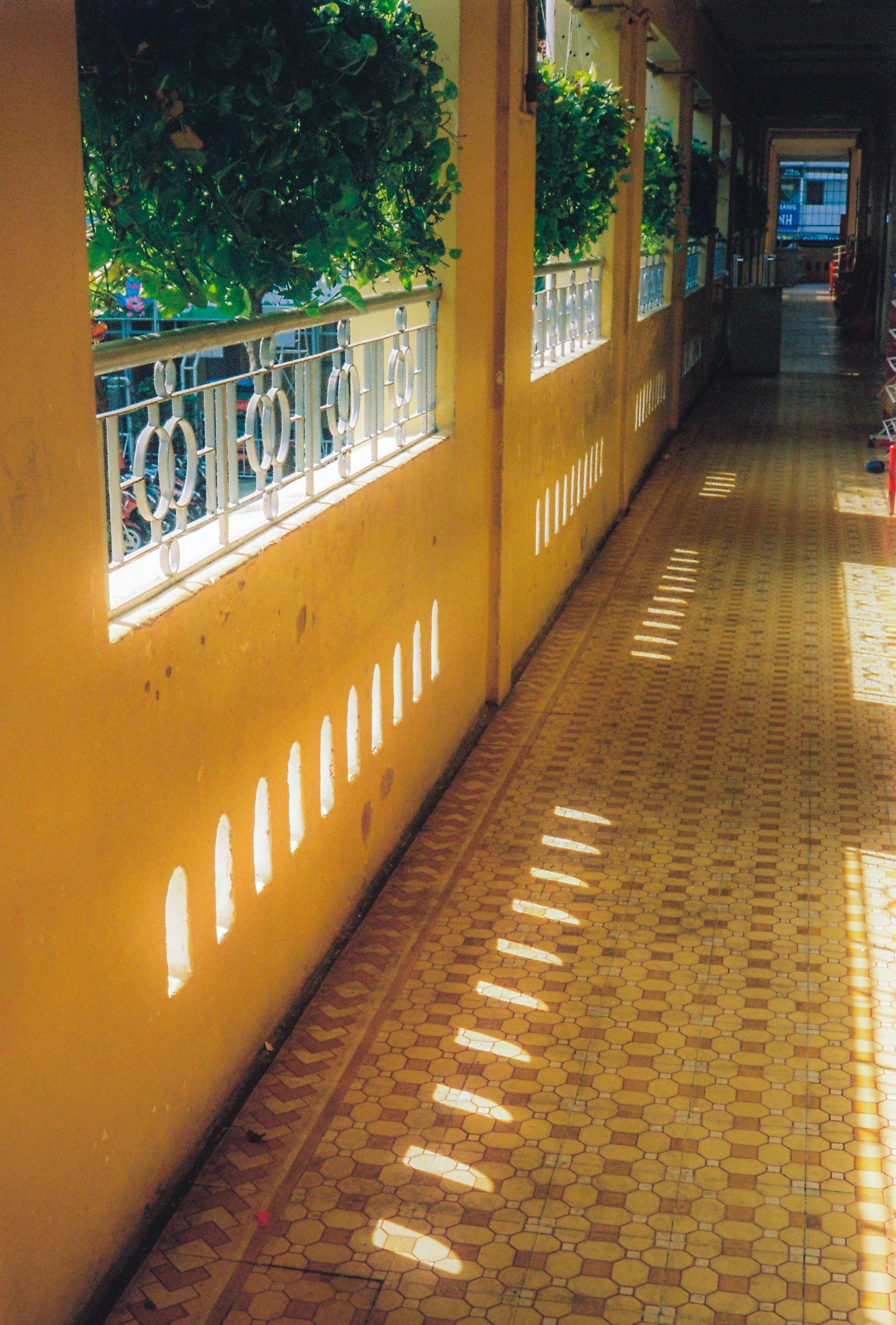 Sunlit Corridor with Patterned Floor Tiles · Free Stock Photo