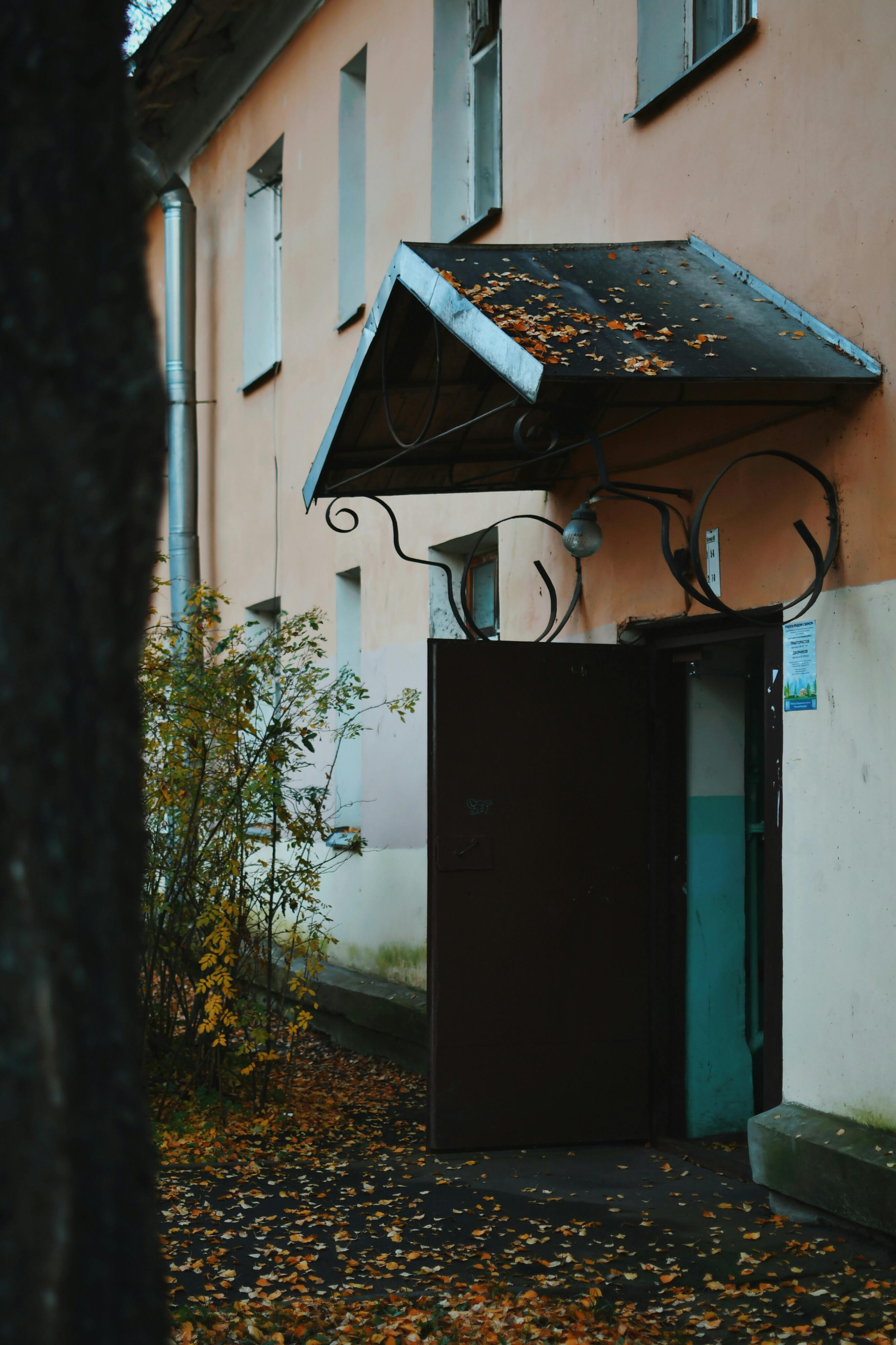 Folhas De Outono Na Entrada Do Prédio Com A Porta Aberta. · Foto ...
