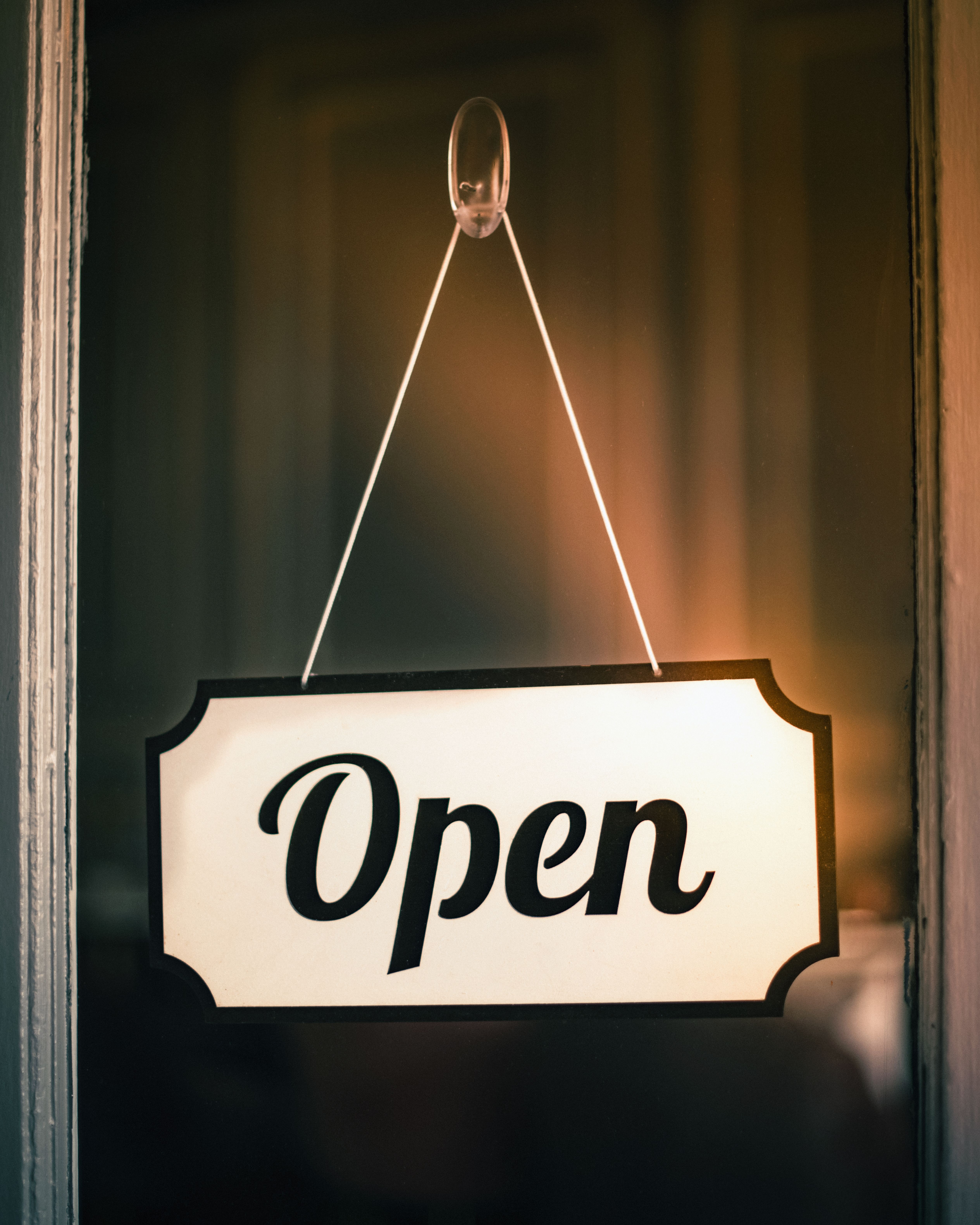 Happy woman showing wooden signboard saying open · Free Stock Photo