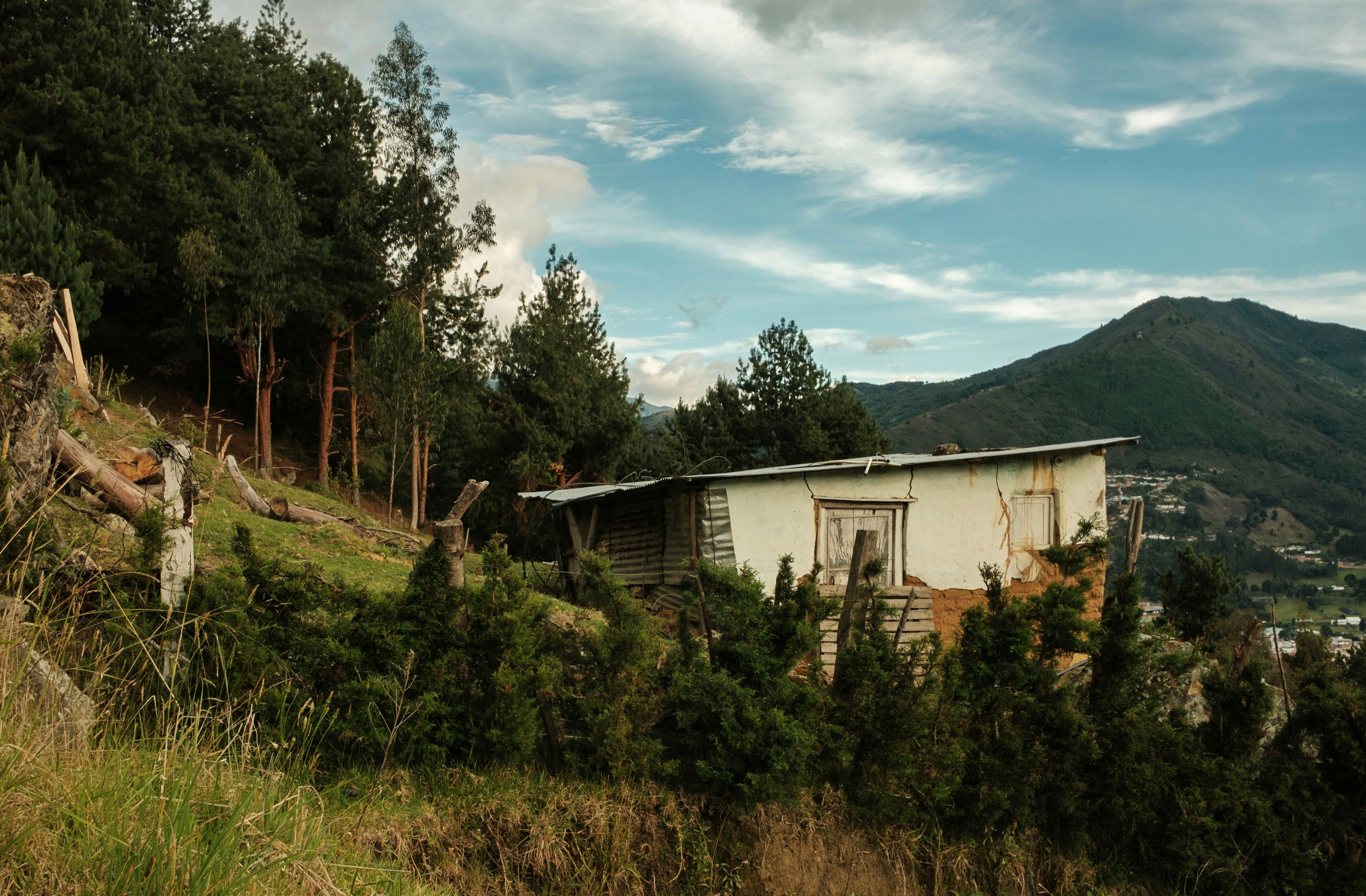 Rustic Hillside Shack in Scenic Mountain Landscape · Free Stock Photo