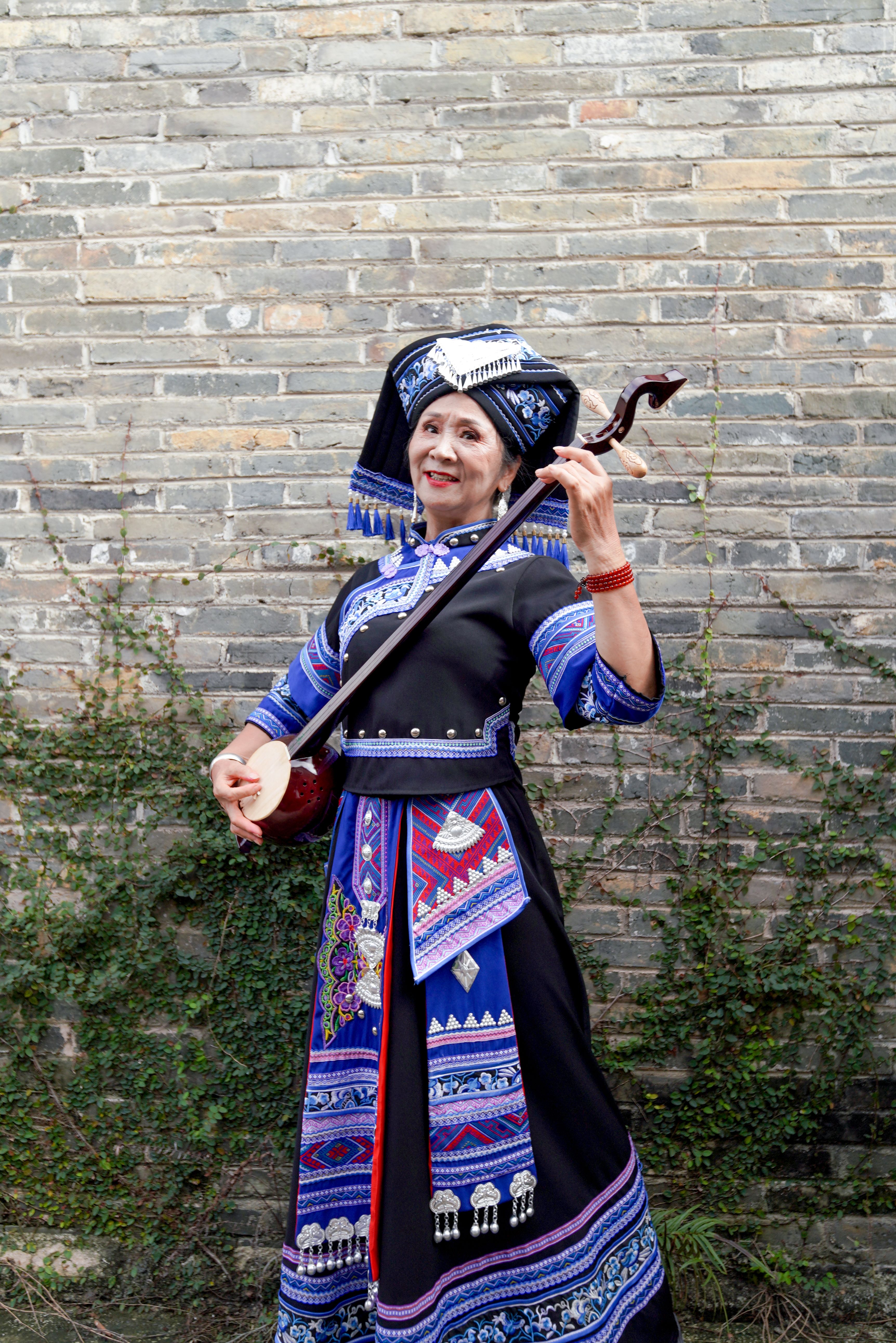 Traditional Zhuang Costume with String Instrument · Free Stock Photo