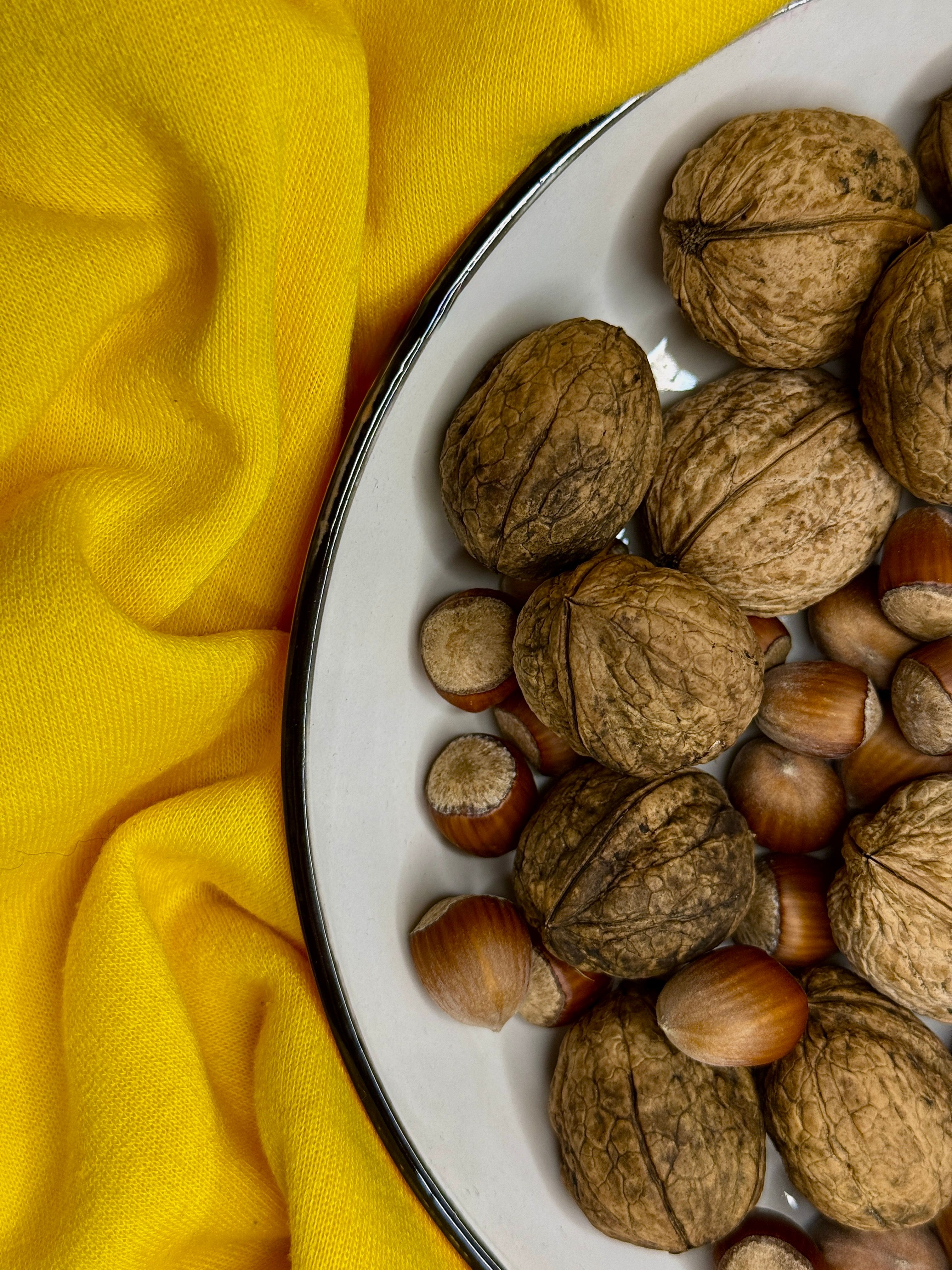 Close-Up of Walnuts and Hazelnuts on Plate · Free Stock Photo
