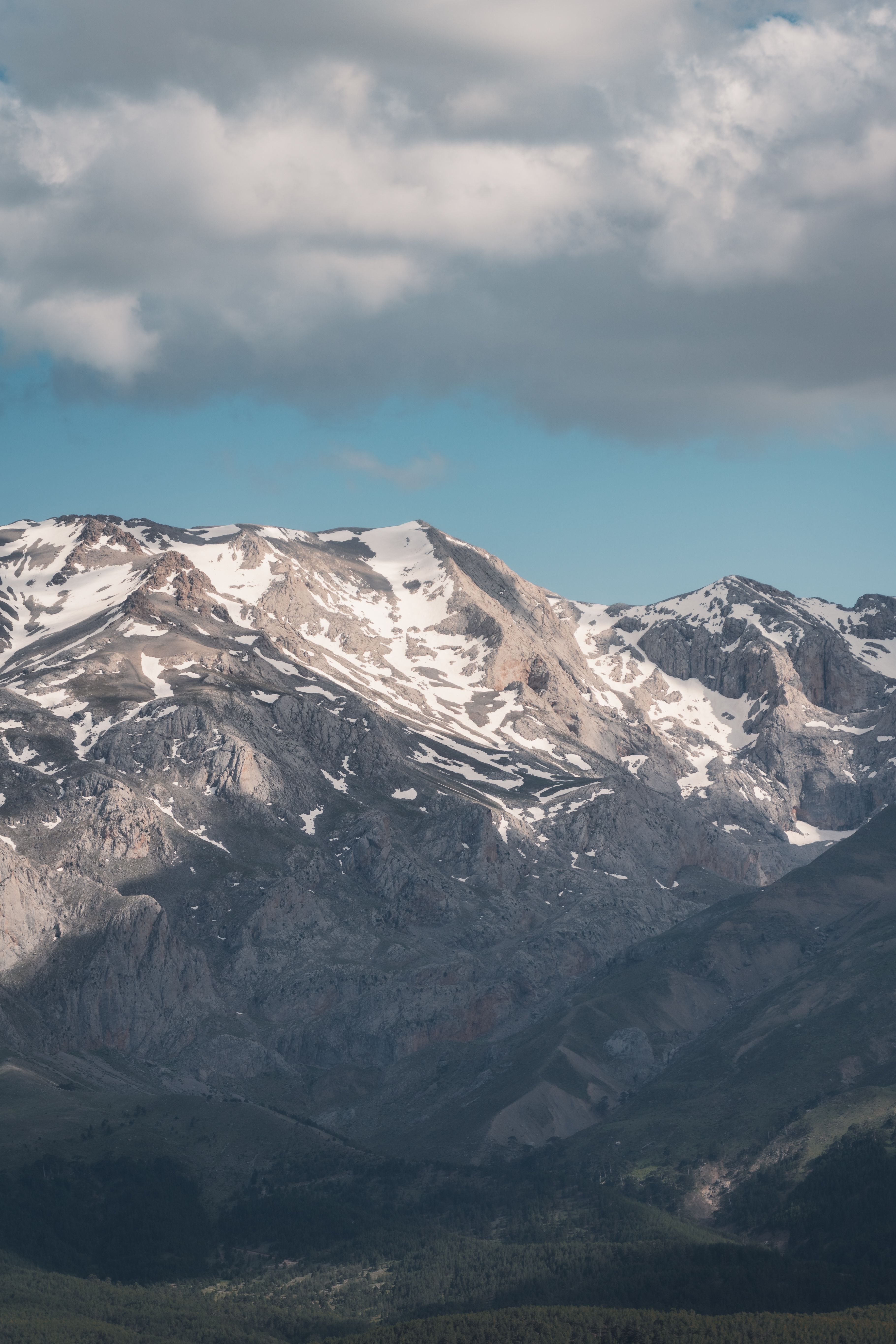 Snow-Capped Mountain Peaks Under Dramatic Clouds · Free Stock Photo