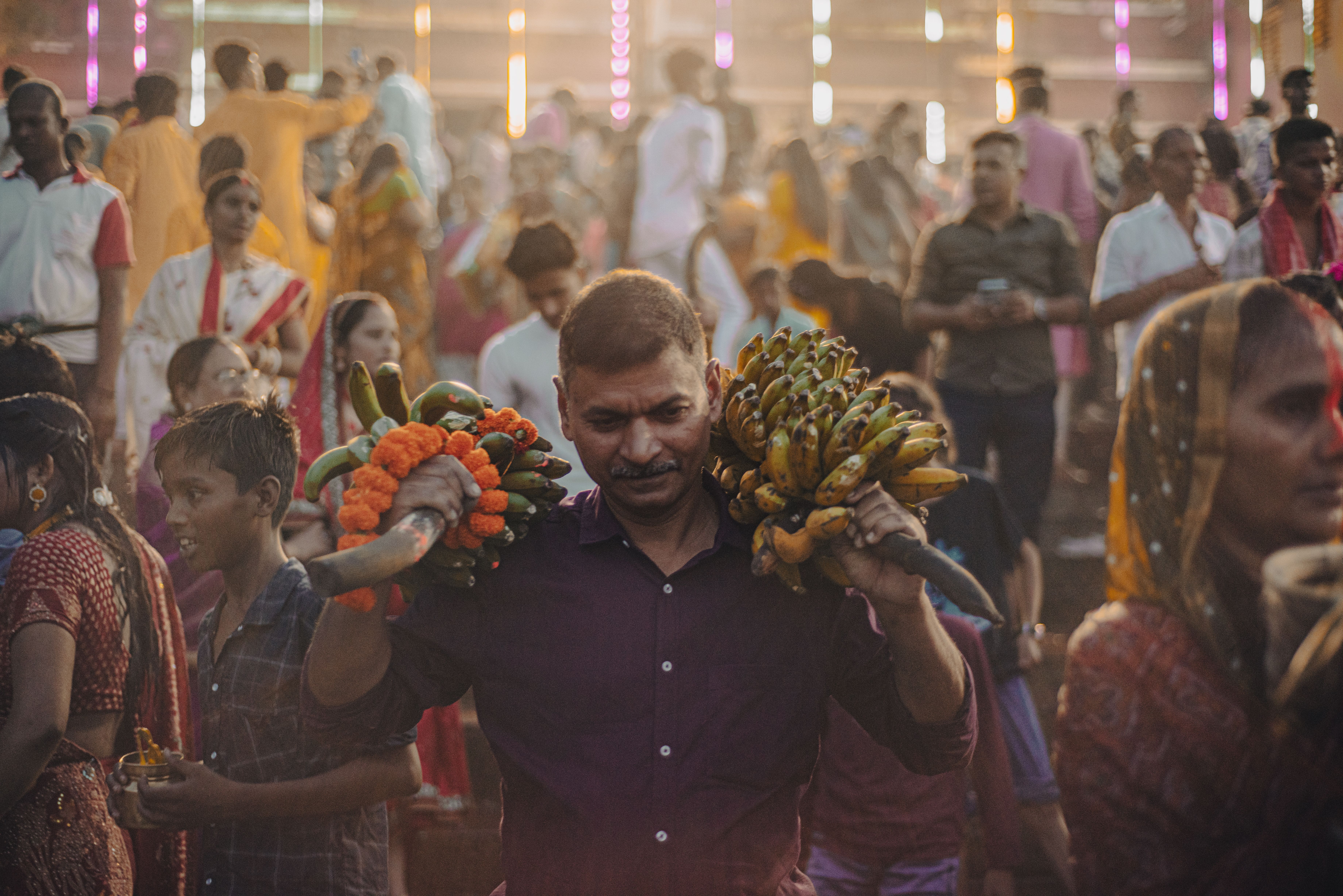 Man Carrying Bananas at Vibrant Cultural Festival · Free Stock Photo