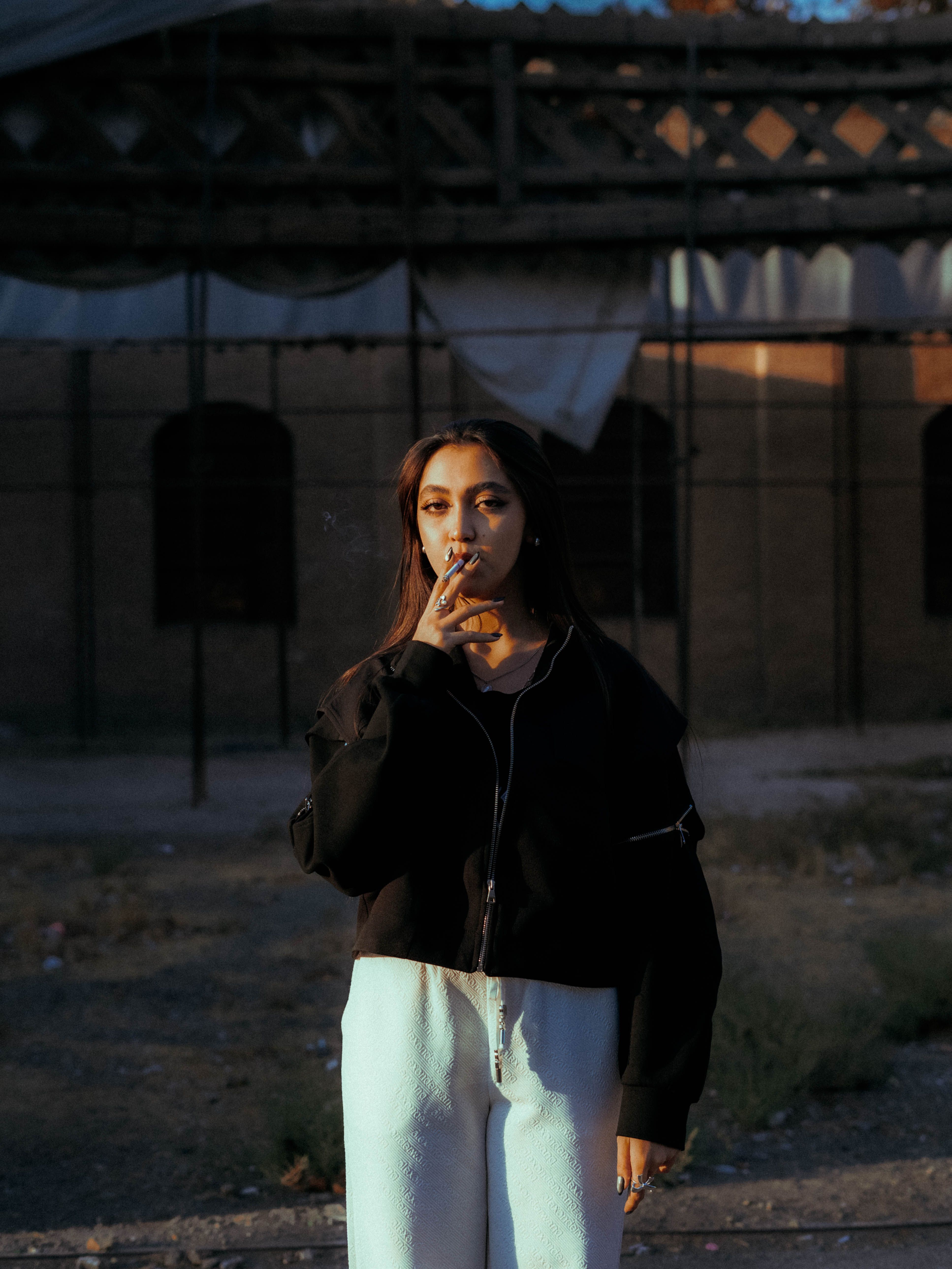 Moody Portrait of Woman Smoking Outdoors · Free Stock Photo