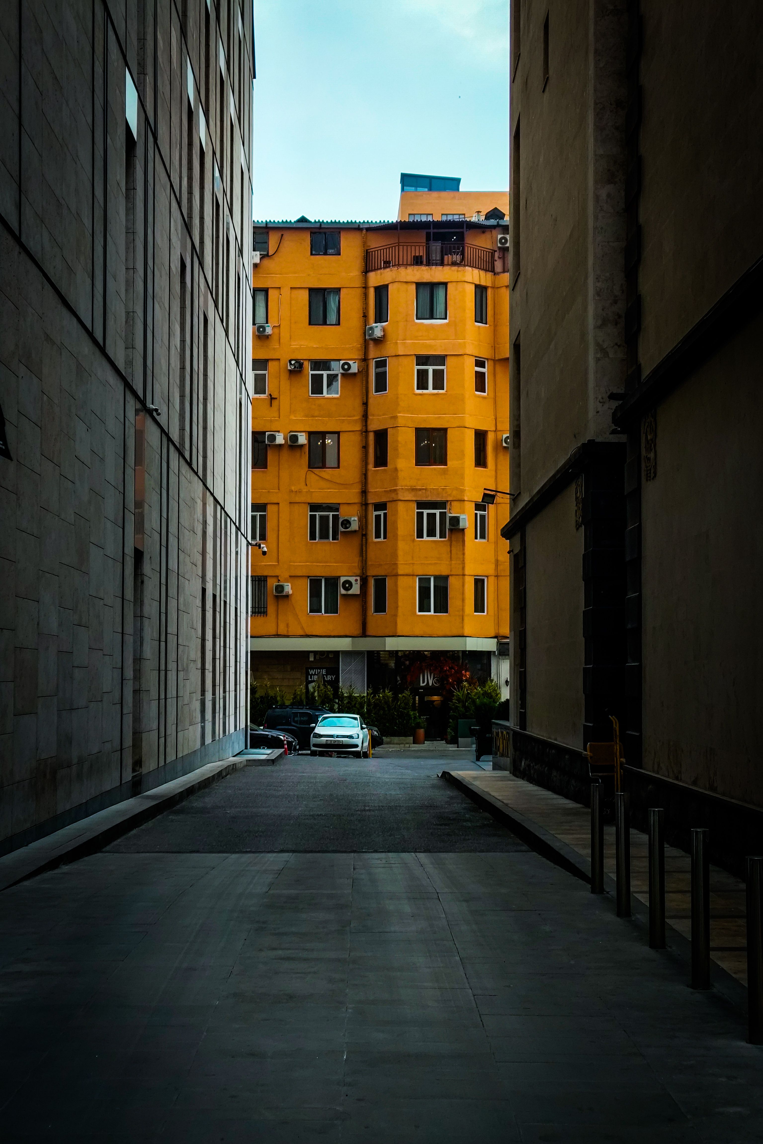 Bright Yellow Building Framed by Urban Alley in Yerevan · Free Stock Photo