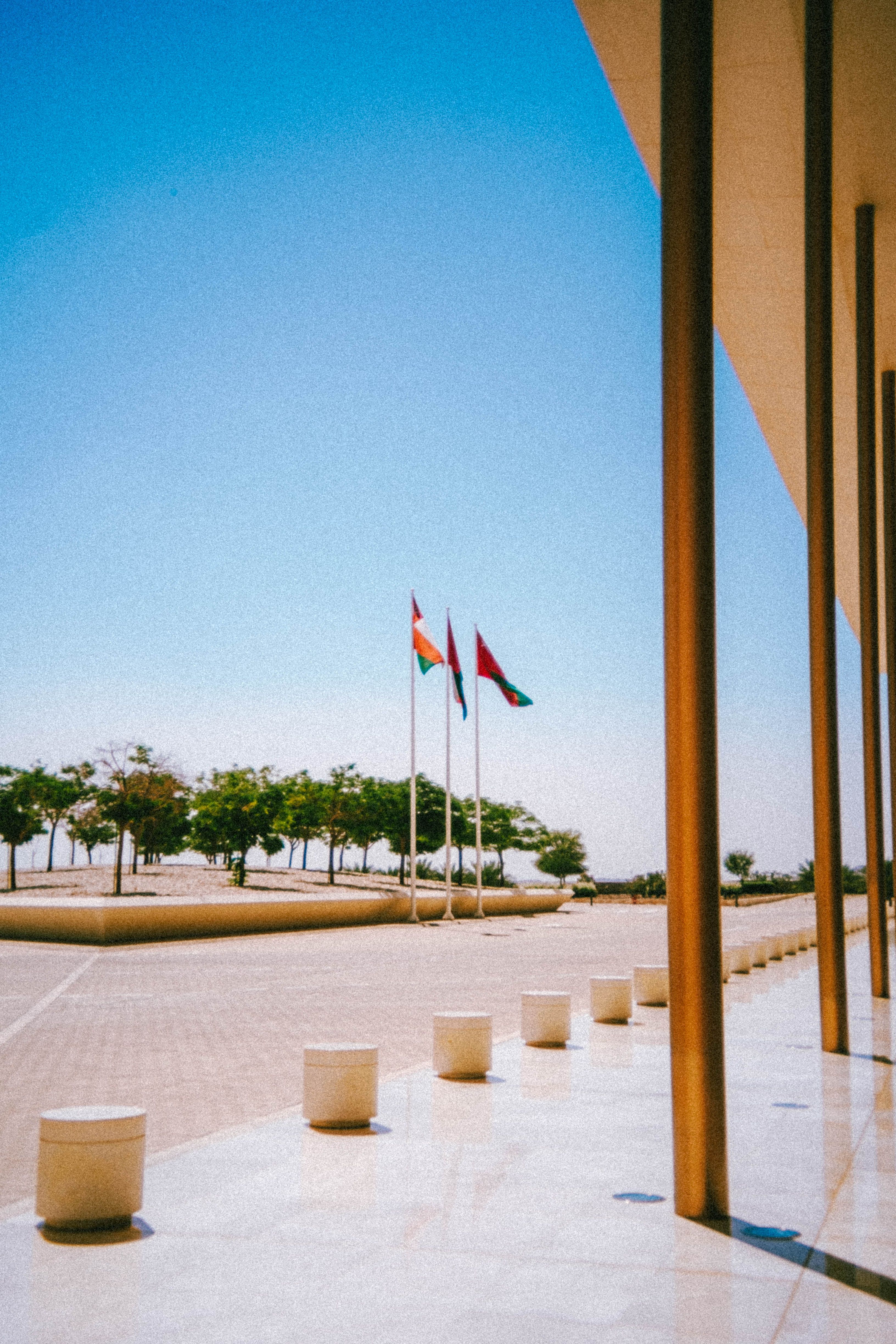 Omani Flags at Modern Architectural Site · Free Stock Photo