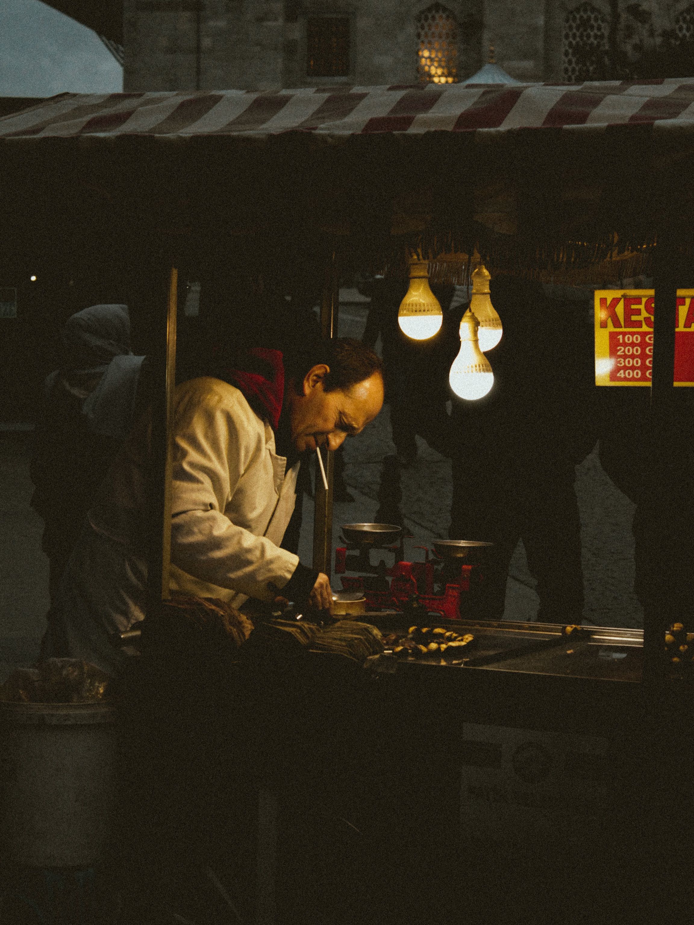Street Vendor Selling Roasted Chestnuts at Night · Free Stock Photo