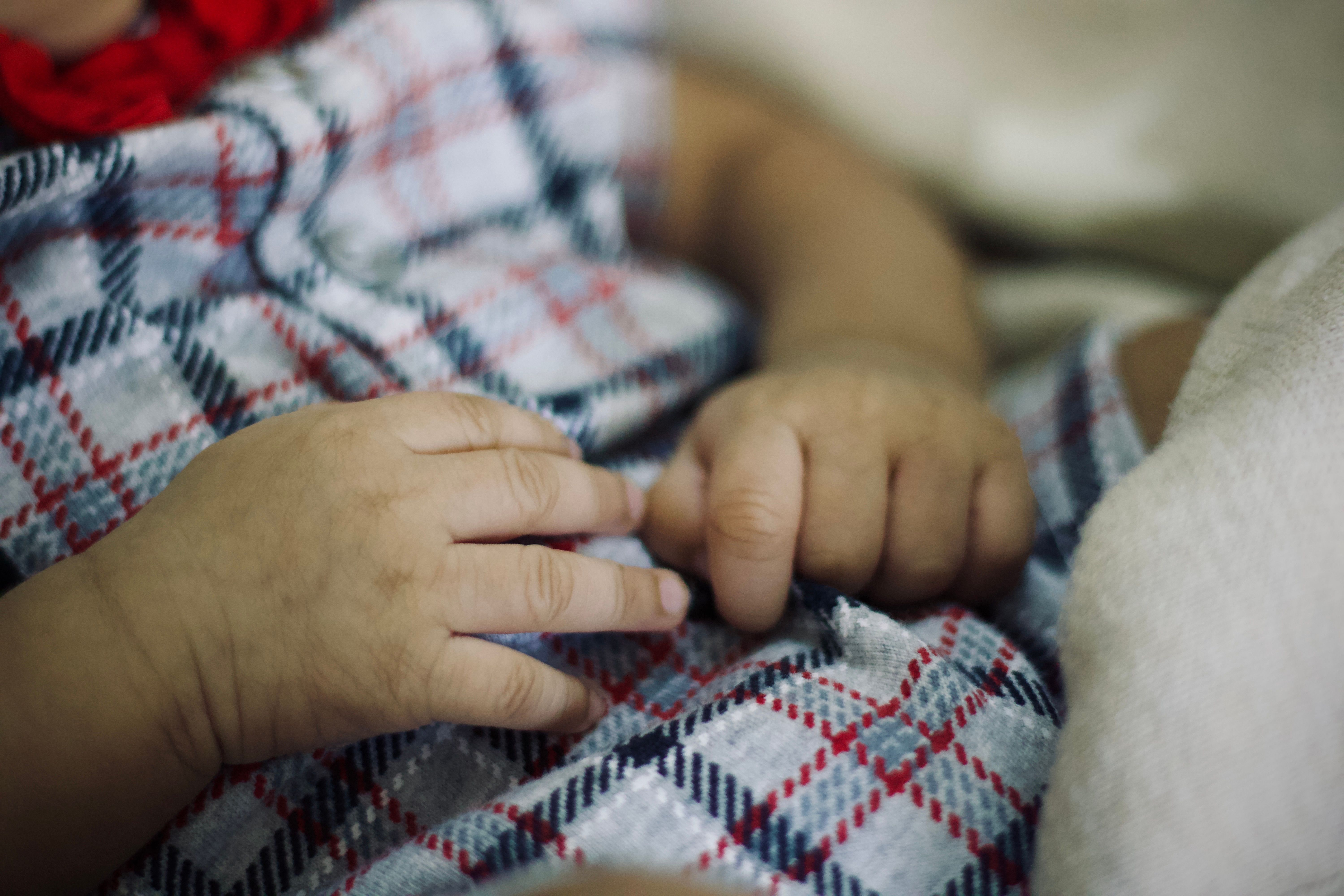 Primer Plano De Las Manos Del Bebé Sobre Una Manta De Cuadros · Foto de ...
